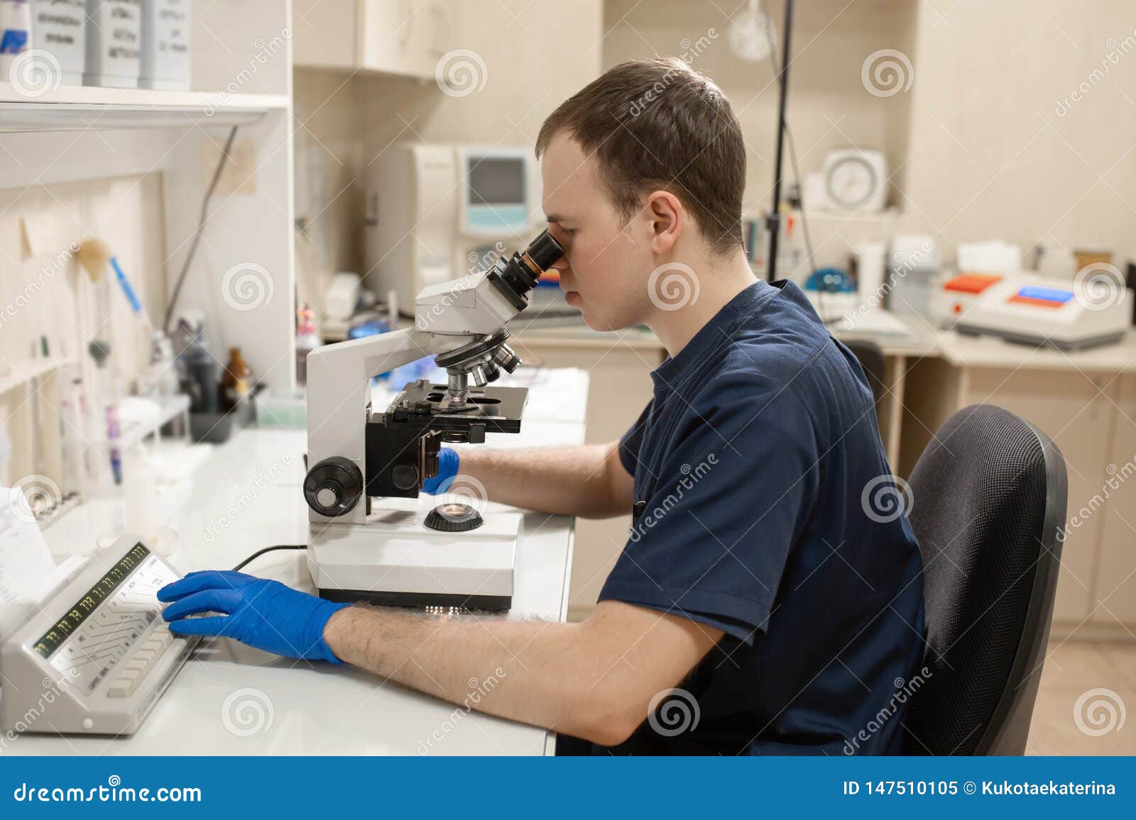 Laboratory Assistant Looking through Microscope. Make Research in ...