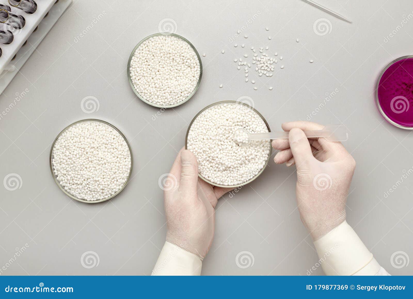 Laboratory Assistant Taking a Sample from a New Batch of White Plastic ...