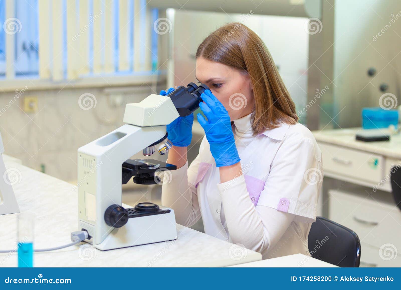 Laboratory Assistant Working with a Microscope in a Scientific ...