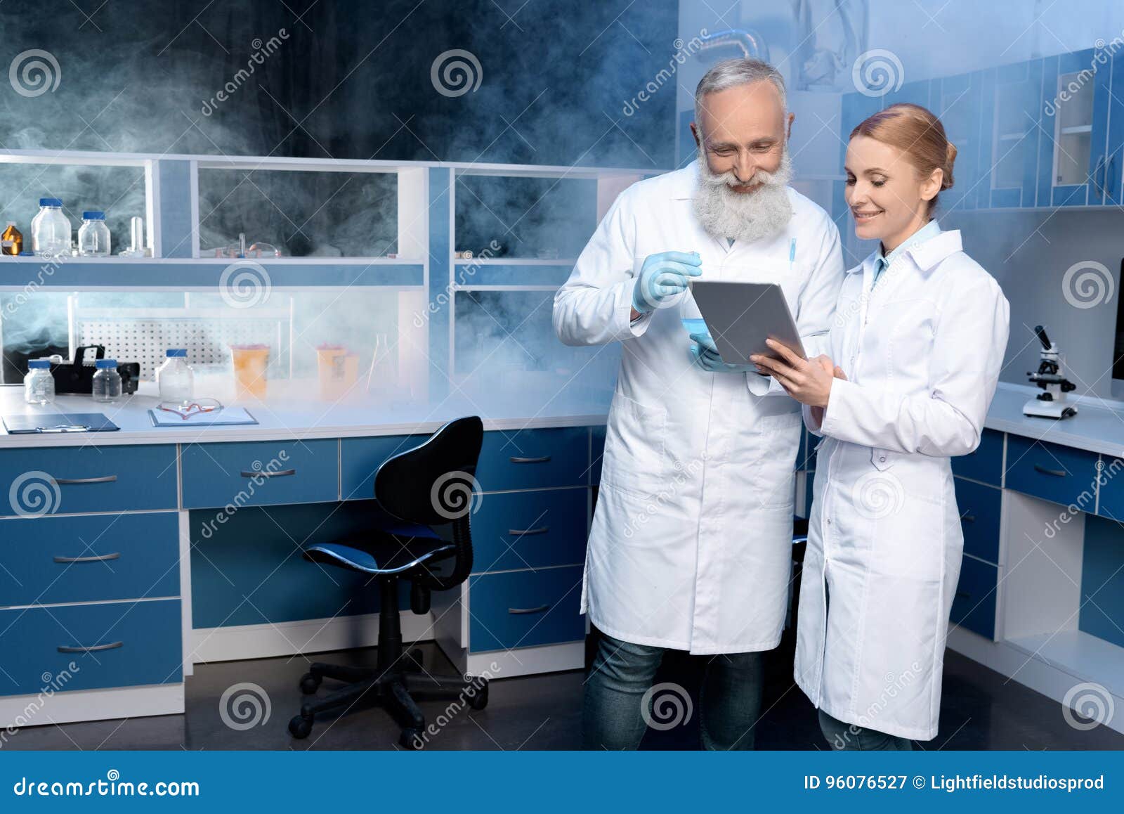 Laboratory Technicians in Lab Coats Looking at Digital Tablet during ...
