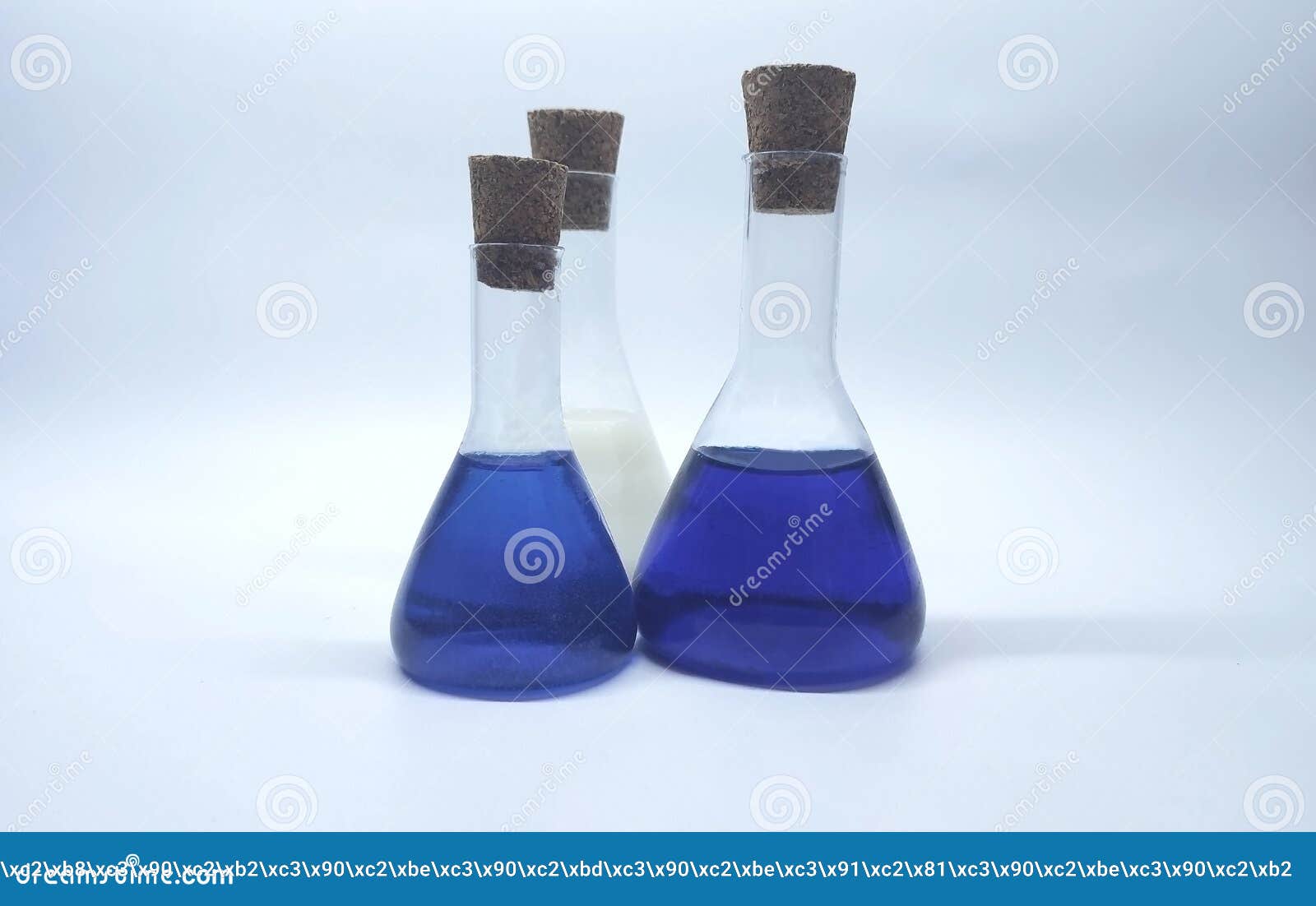 Three Laboratory Conical Flasks with Blue and White Liquid and Wooden ...