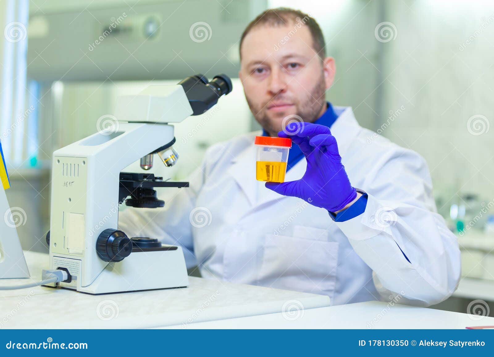 Laboratory Worker Performing Urinalysis Using Microscope and Laboratory ...