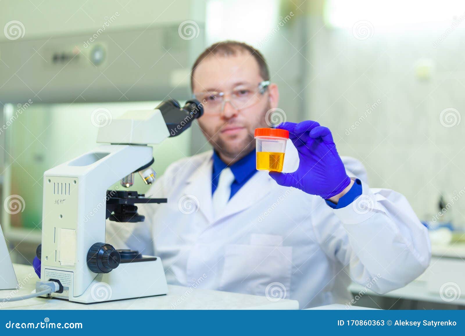 Laboratory Worker Performing Urinalysis Using Microscope and Laboratory ...
