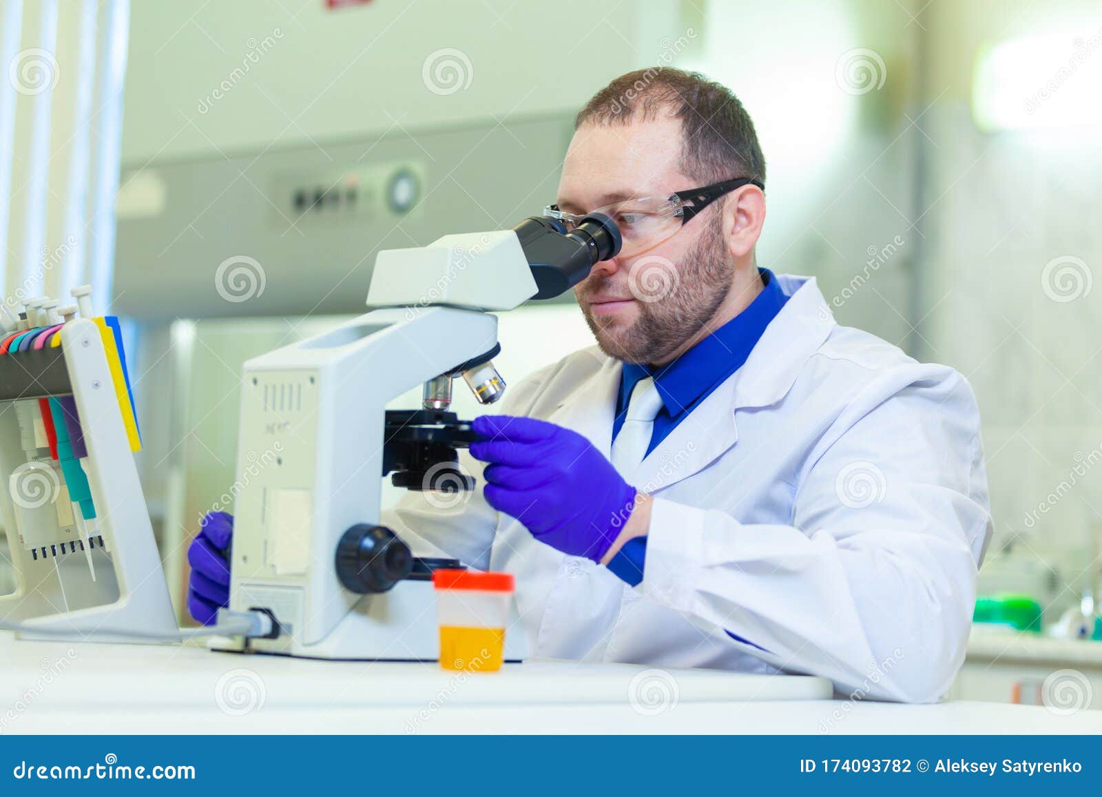 Laboratory Worker Performing Urinalysis Using Microscope and Laboratory ...