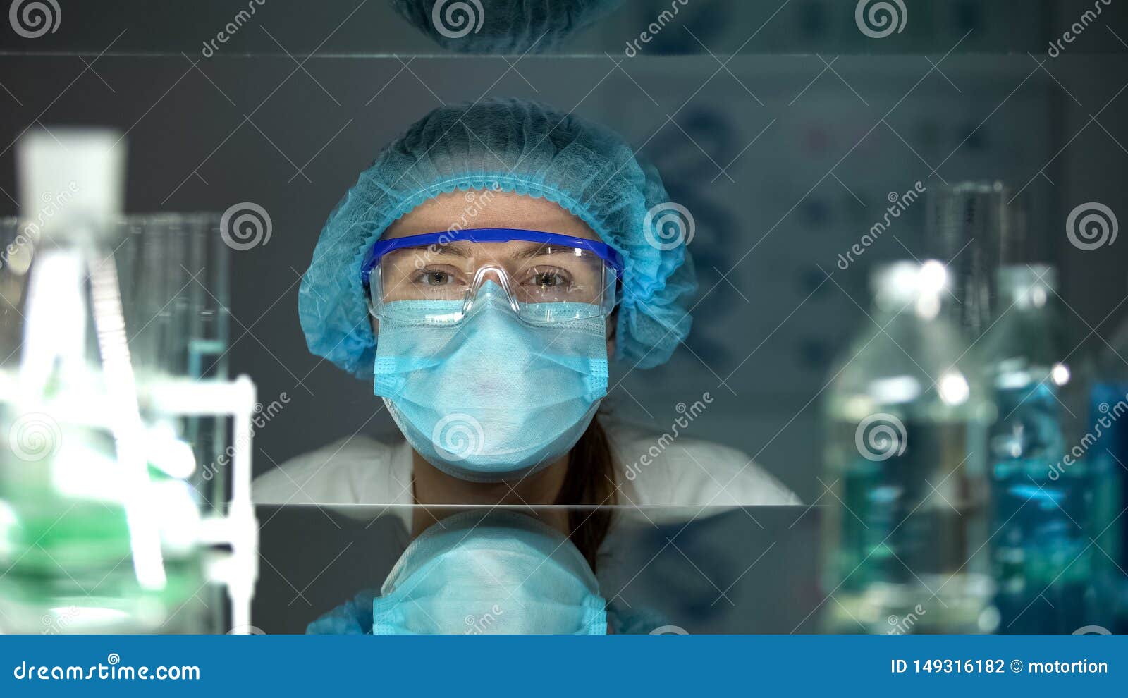 Laboratory Worker in Protective Eyeglasses and Uniform Looking at ...