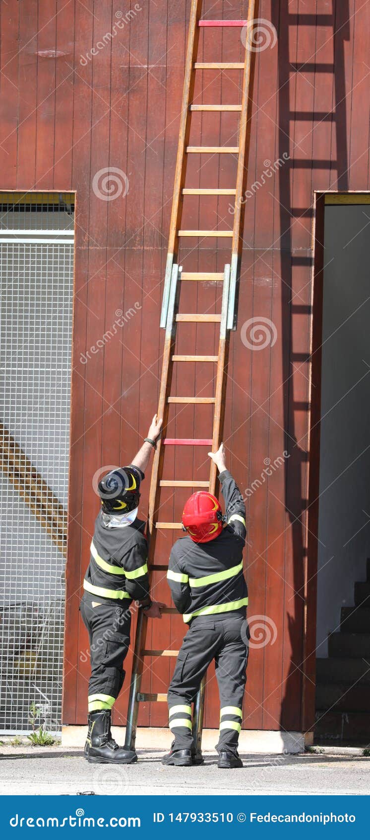 Ladder and Two Firefighter with Helmet in the Fire Station Stock Photo ...