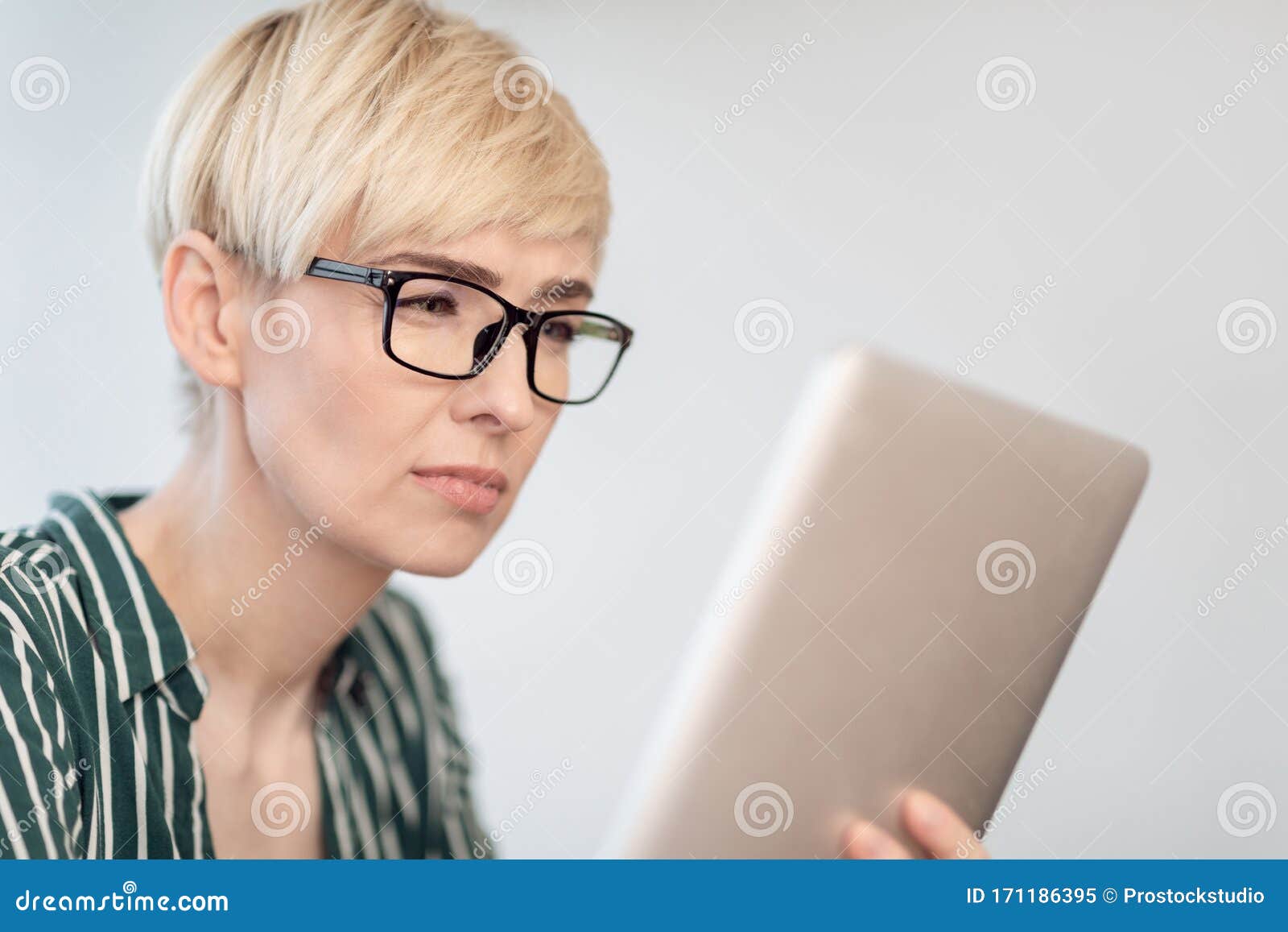 Lady in Eyeglasses Using Tablet Squinting Eyes Sitting Indoor Stock ...
