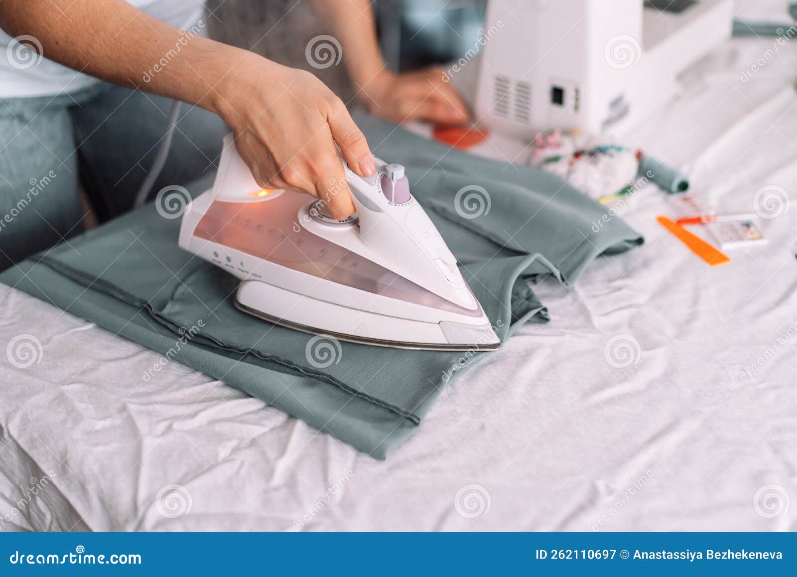 Lady Steam Ironing the Fabric in Front of the Sewing Equipment Stock ...
