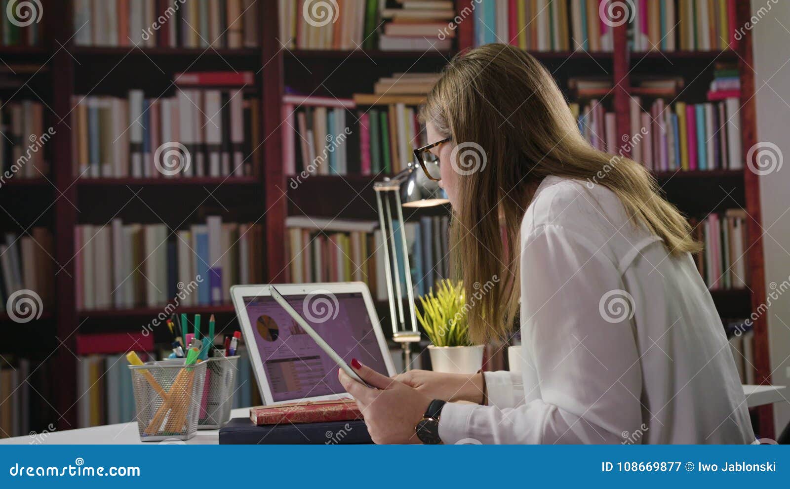 A Lady Using a Laptop and a Tablet in the Library Stock Image - Image ...