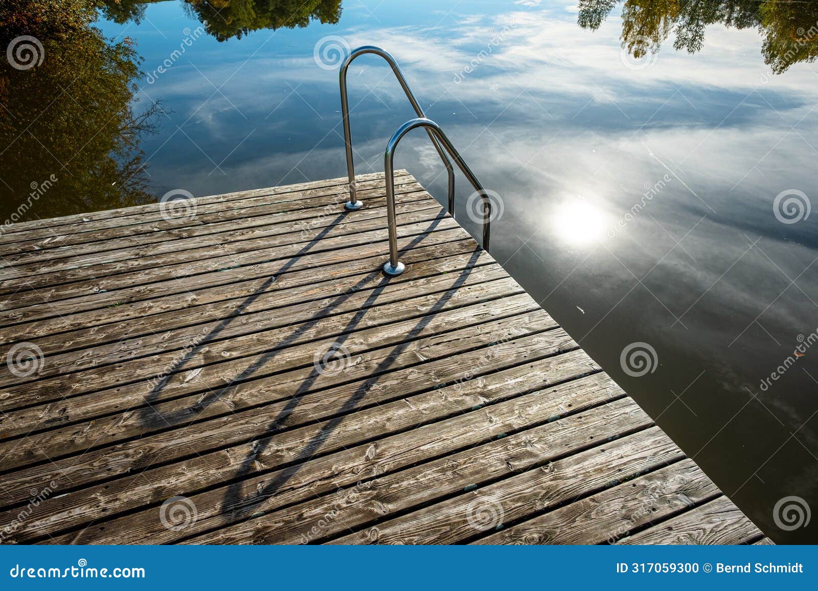 Lake and Dock with Sun Mirroring in Water Stock Photo - Image of ...