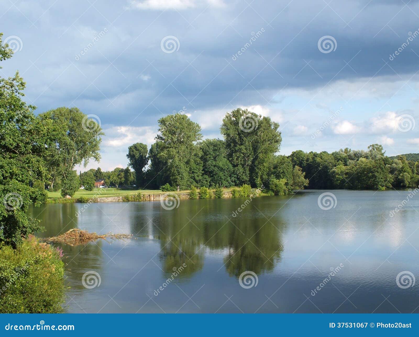 A lake framed by greenery stock image. Image of countryside - 37531067