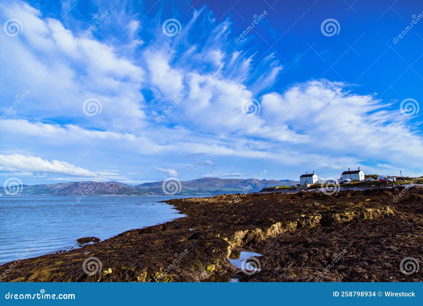 Lake Inlet Surrounded by Mountains and Buildings Under a Cloudy Sky ...