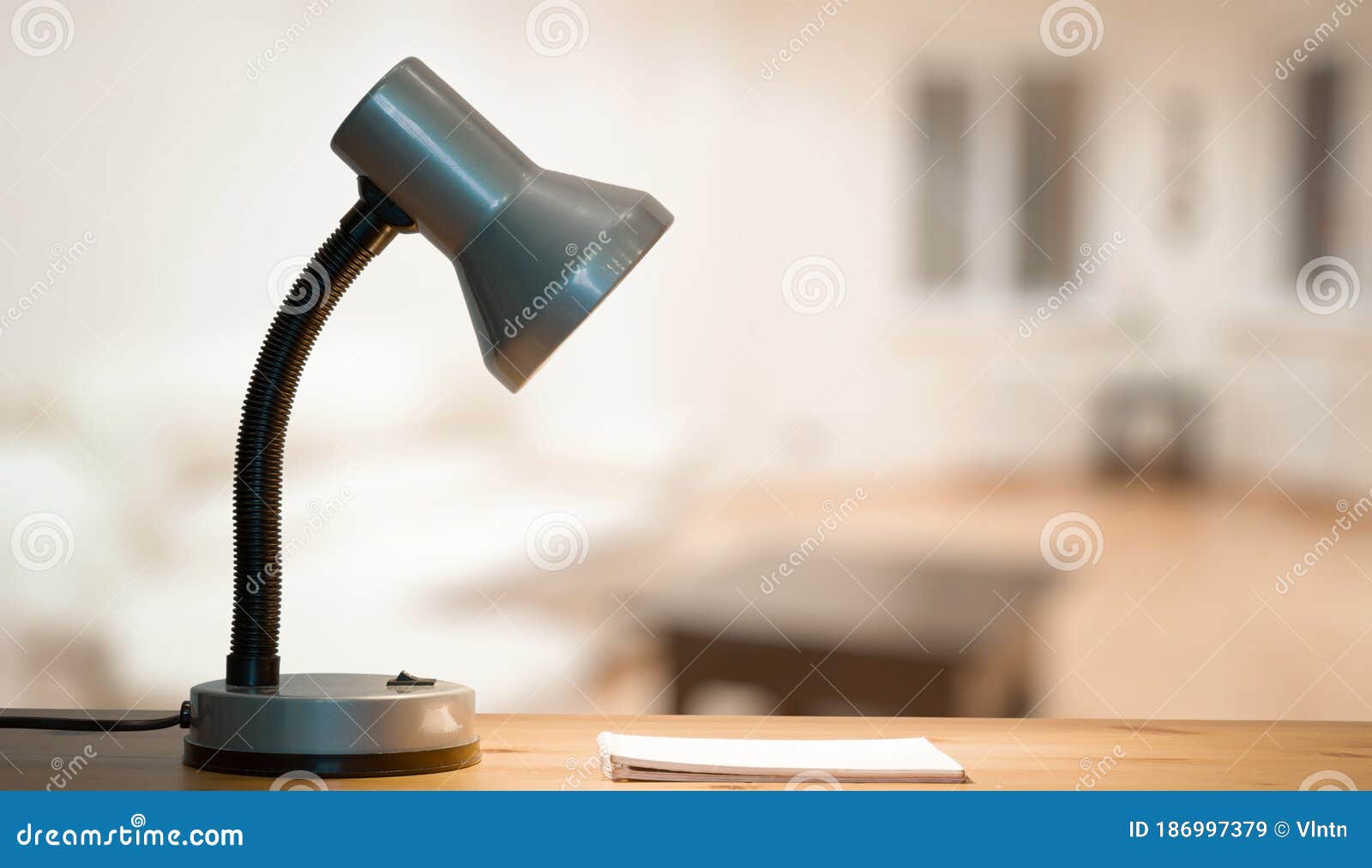 Lamp and notebook on table stock image. Image of workplace - 186997379