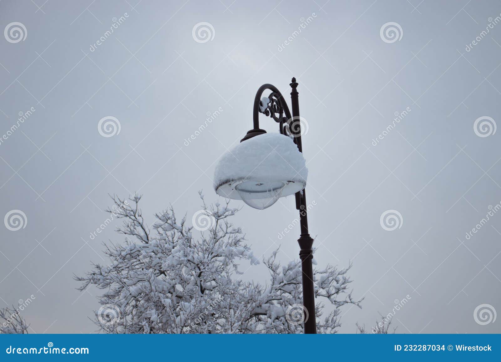 Lamp Post in Winter Covered in Snow with a Cloudy Sky Stock Photo ...