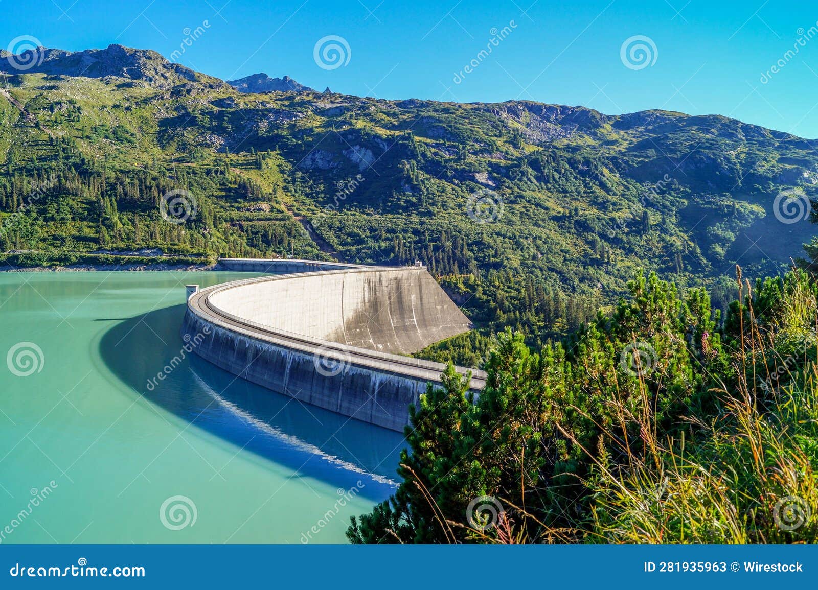 Landscape of a Dam Surrounded by Hills and Greenery Under a Blue Sky in ...