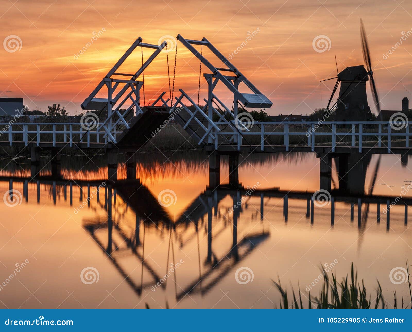 Landscape Shot of a Bridge and Windmill in an Orange Sunset Stock Image ...
