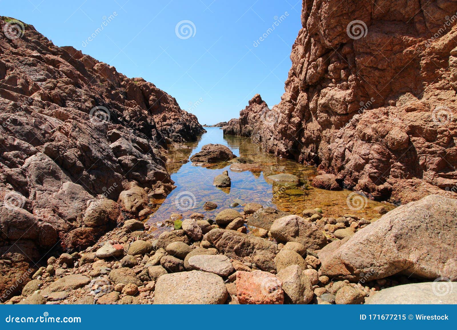 Landscape Shot of a Seashore Surrounded with Big Rocks on Each Side in ...