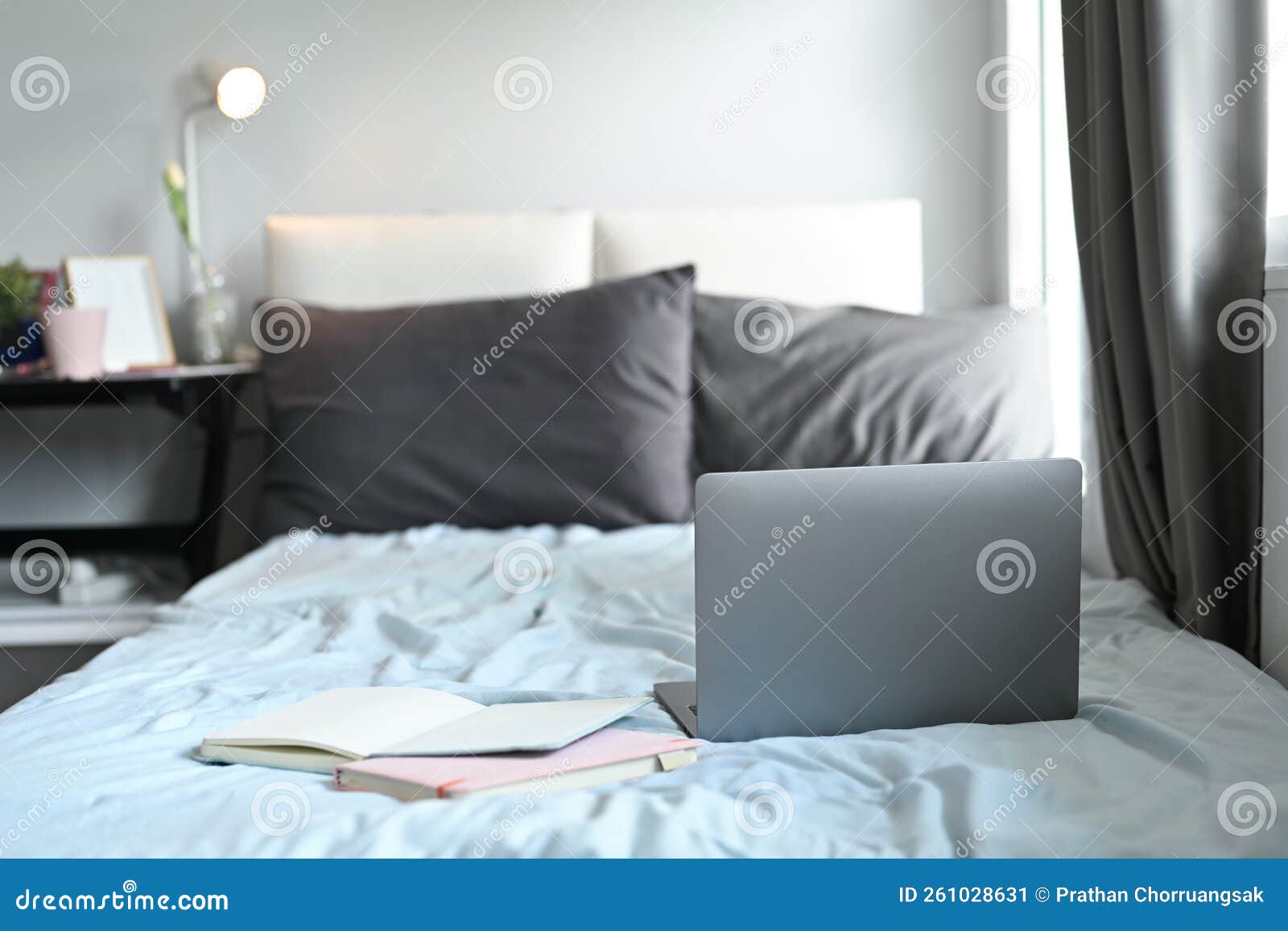 Laptop Computer and Notebooks on Bed with Soft Light from Window Stock ...