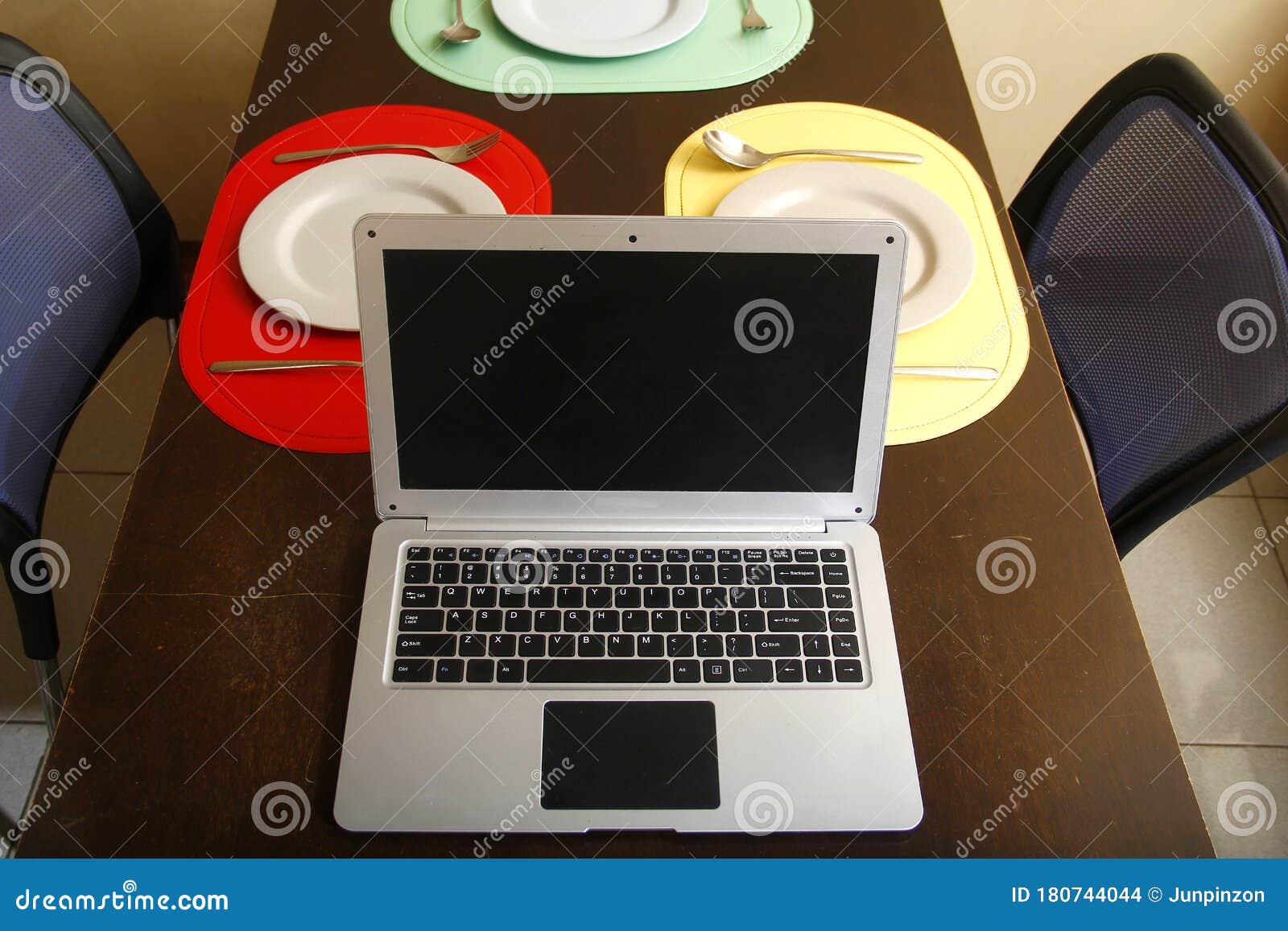 Laptop Computer, Plates and Utensils on a Dining Table Stock Photo ...