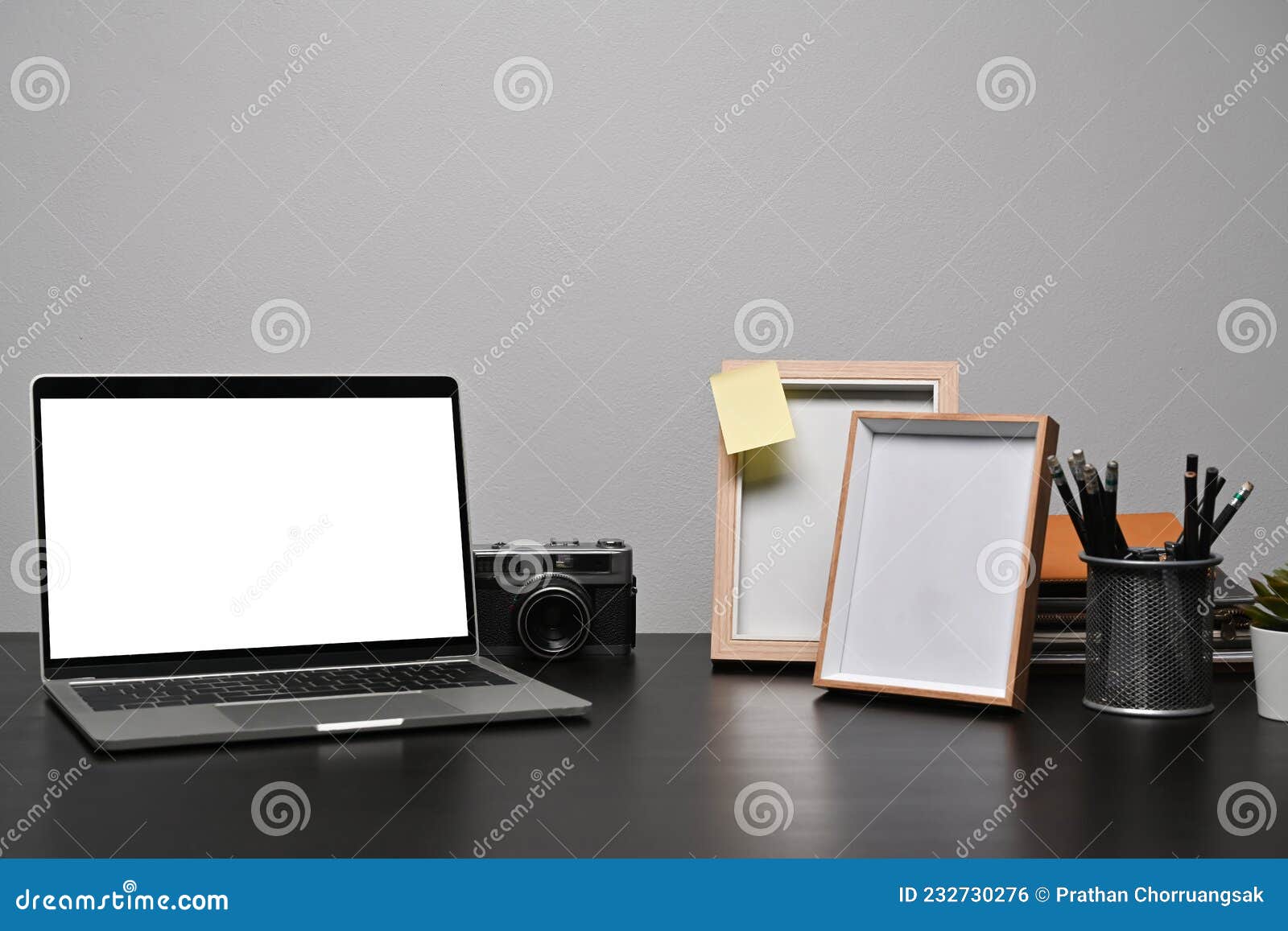 Laptop With White Screen, Camera And Empty Picture Frames On Black ...