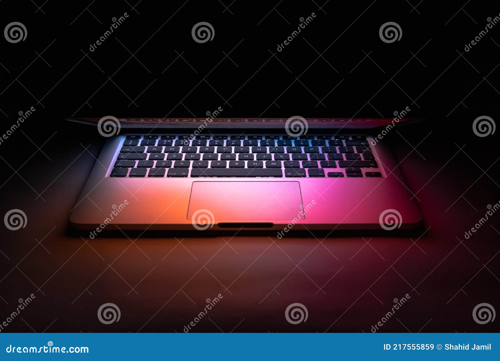 A Laptop Half Closed in the Dark with Colourful Glow Stock Image ...