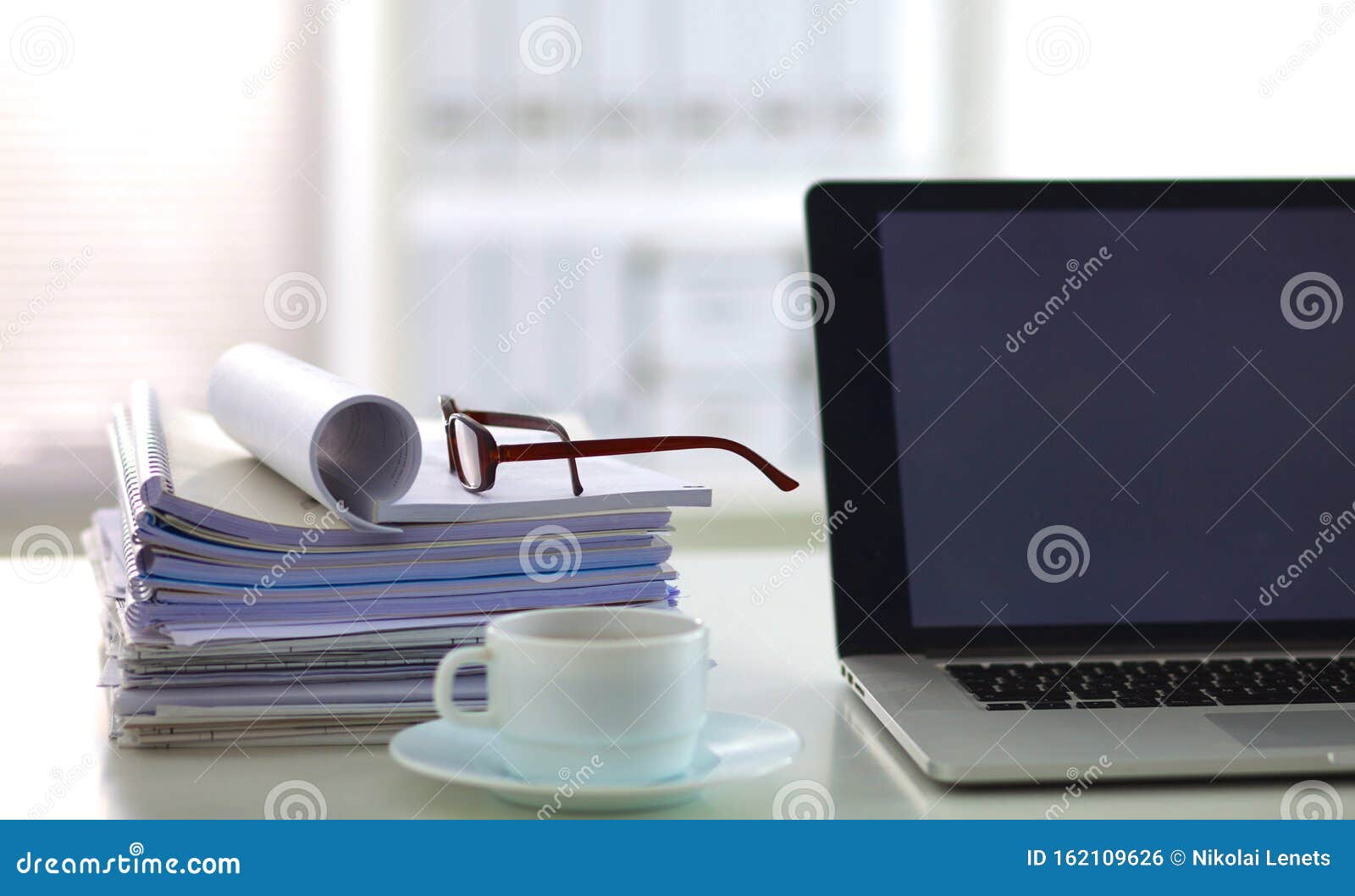 Laptop with Stack of Folders on Table on White Background Stock Photo ...
