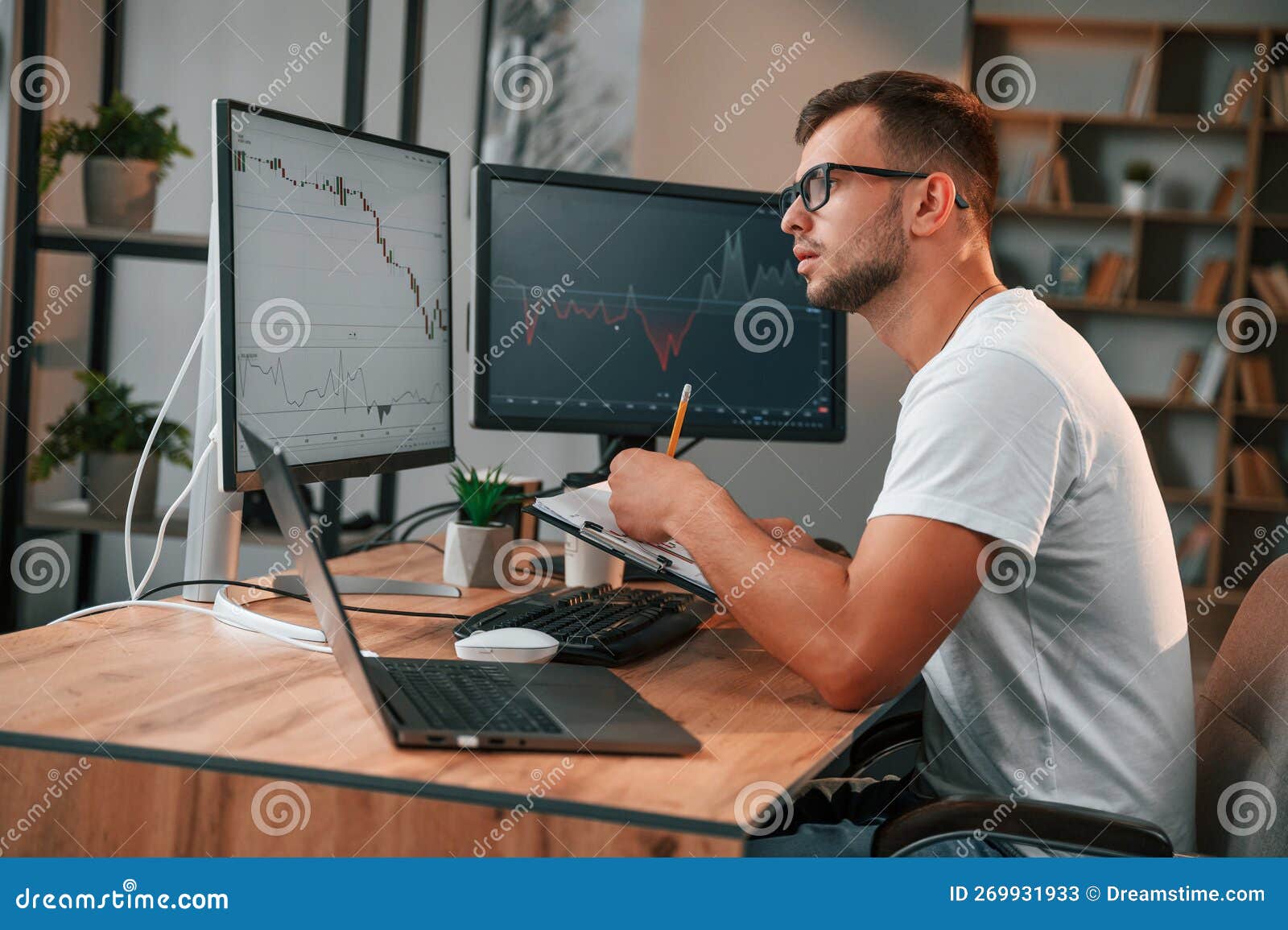 Laptop is on the Table. Young Stock Broker is Working in the Office by ...