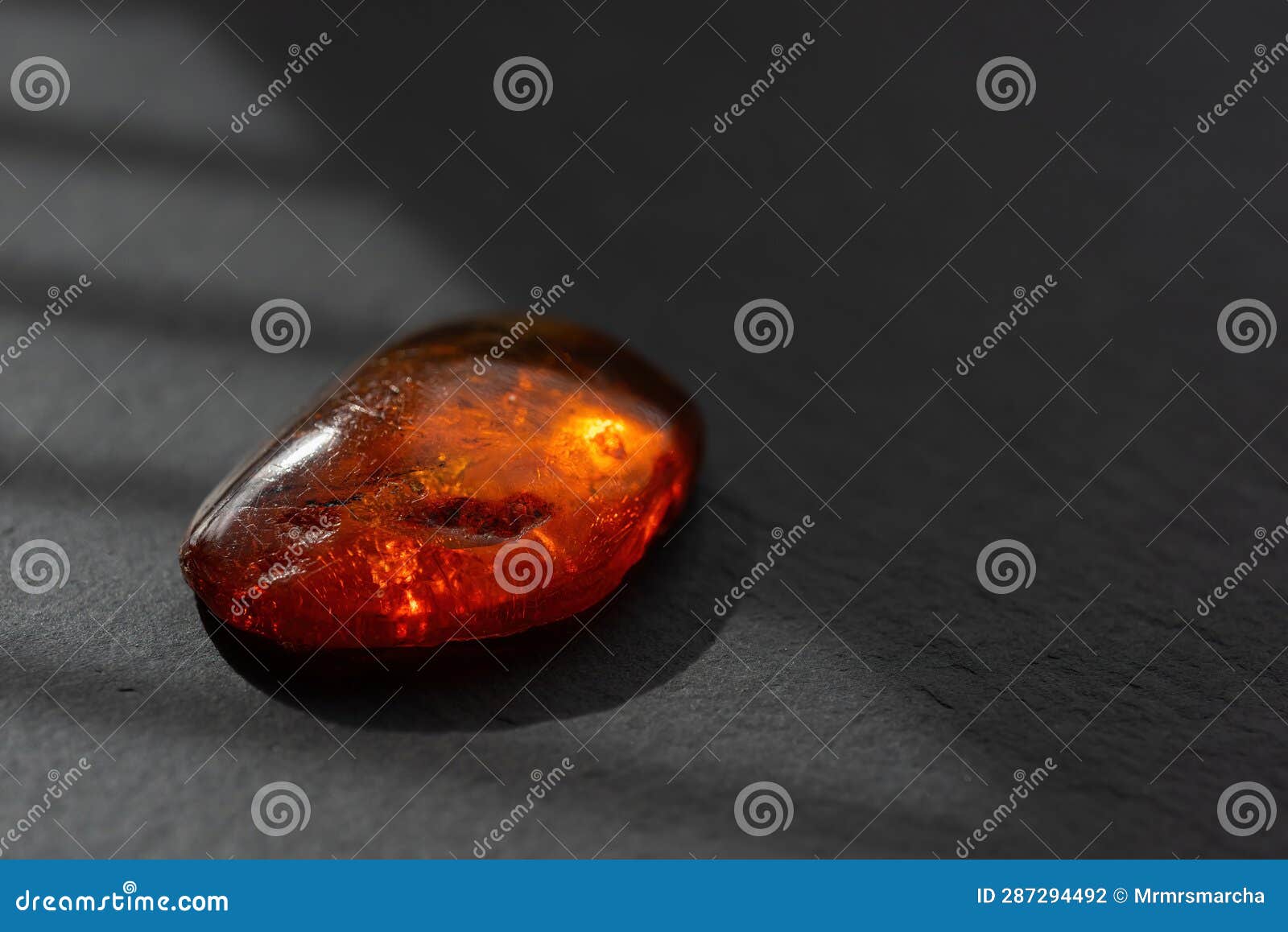 Large Amber Stone Illuminated by Sunlight on a Black Background Close ...
