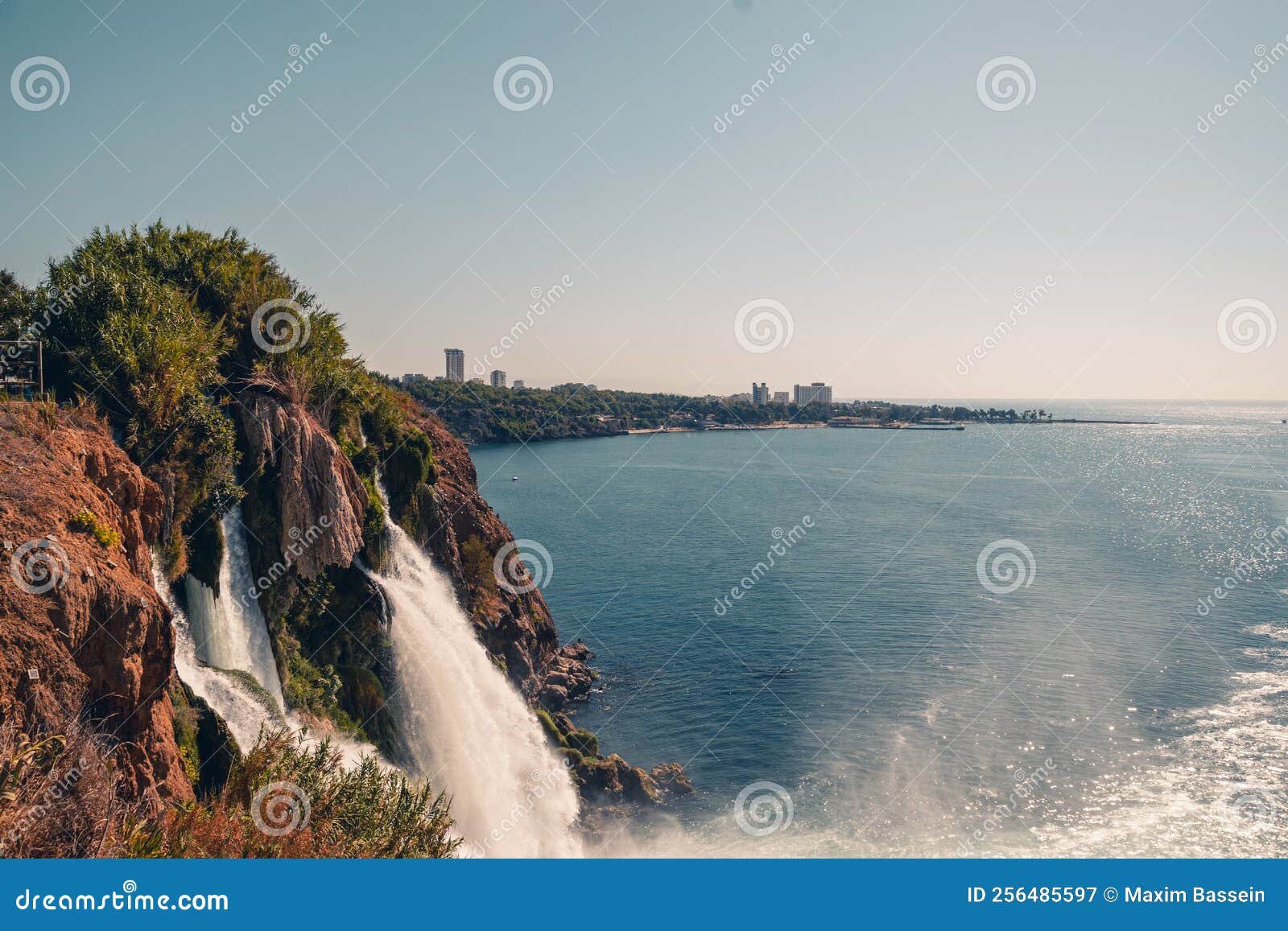 A Large Beautiful Waterfall Flows from the Cliff into the Sea Stock ...