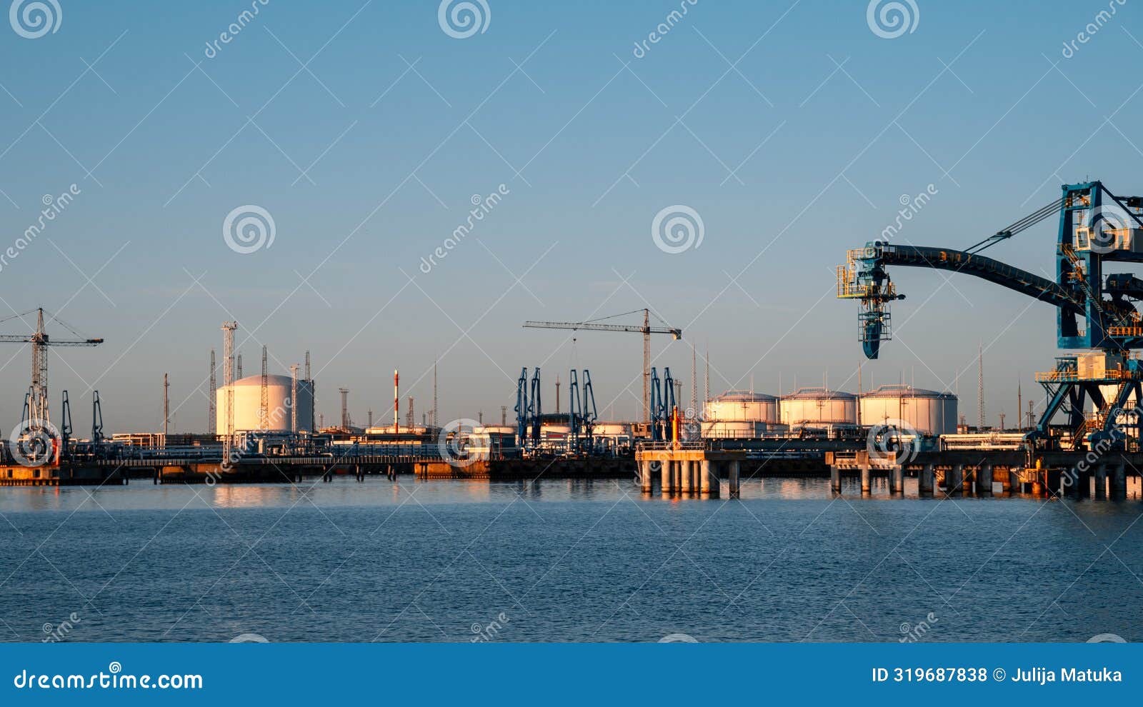 A Large Blue Crane is Lifting a Large Container from a Ship Stock Photo ...