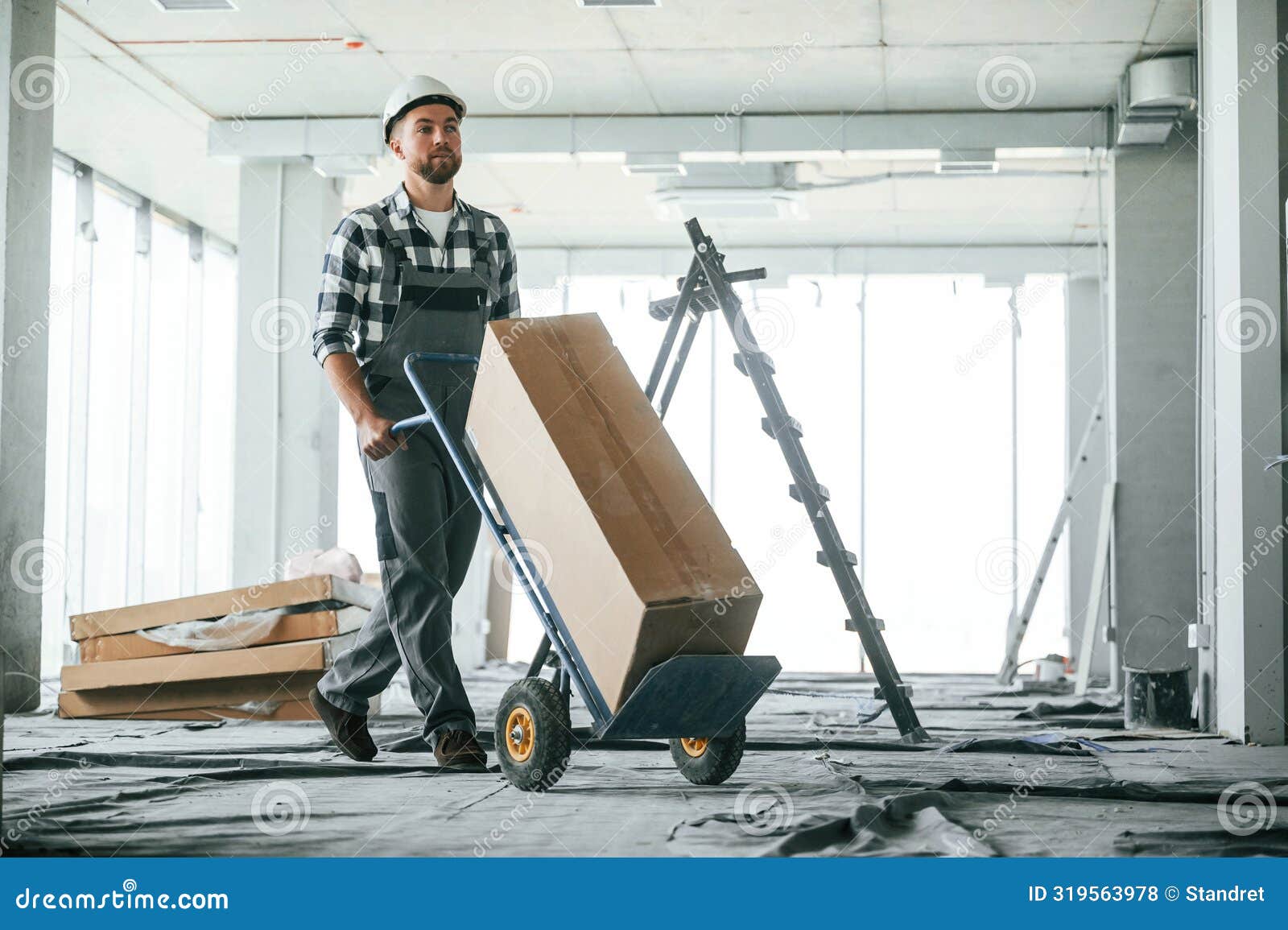 With Large Box, Transporting the Material. Construction Worker in ...