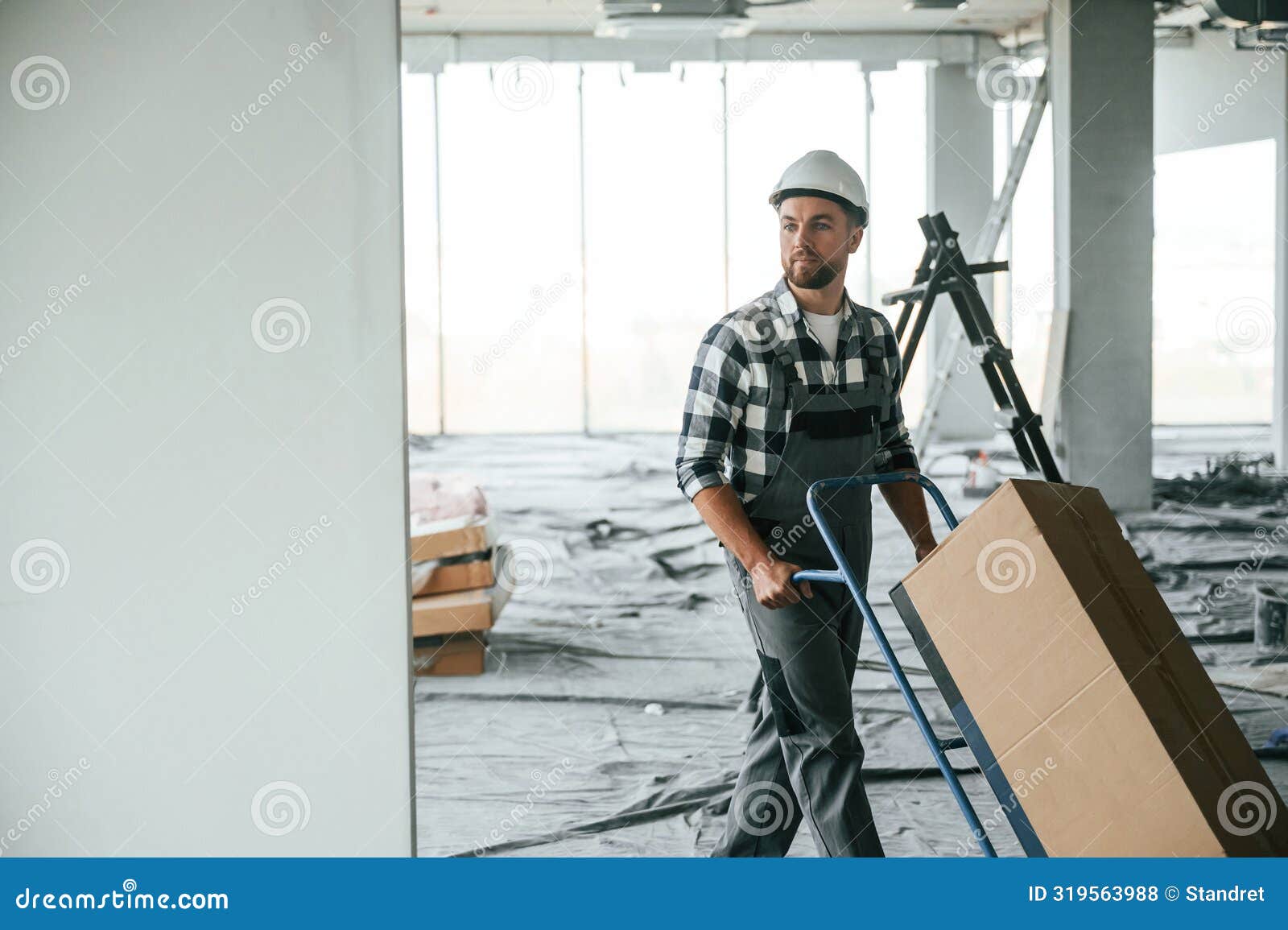 With Large Box, Transporting the Material. Construction Worker in ...