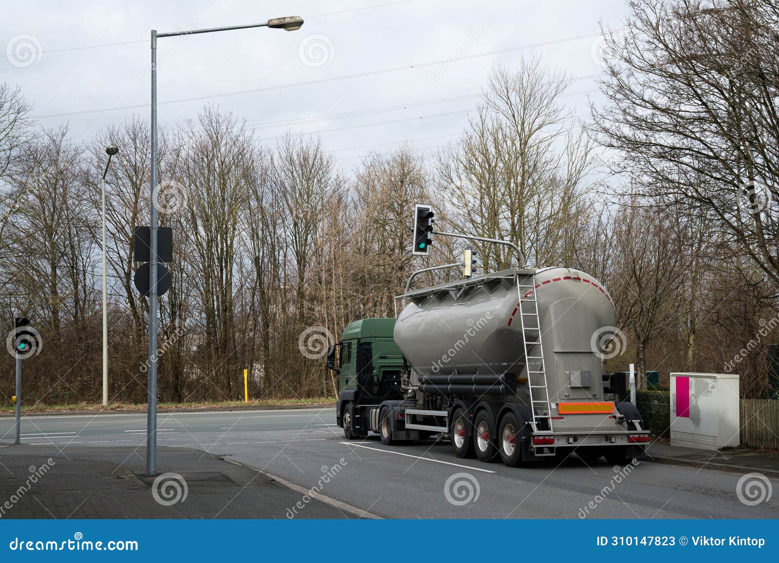 A Large Car with a Tank at an Empty Intersection with a Traffic Light ...