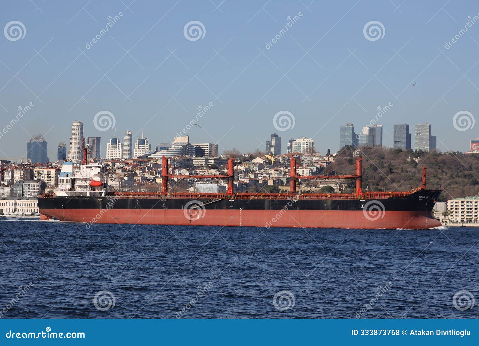 Large Cargo Ship Navigating the Bosphorus with Istanbul City Skyline in ...