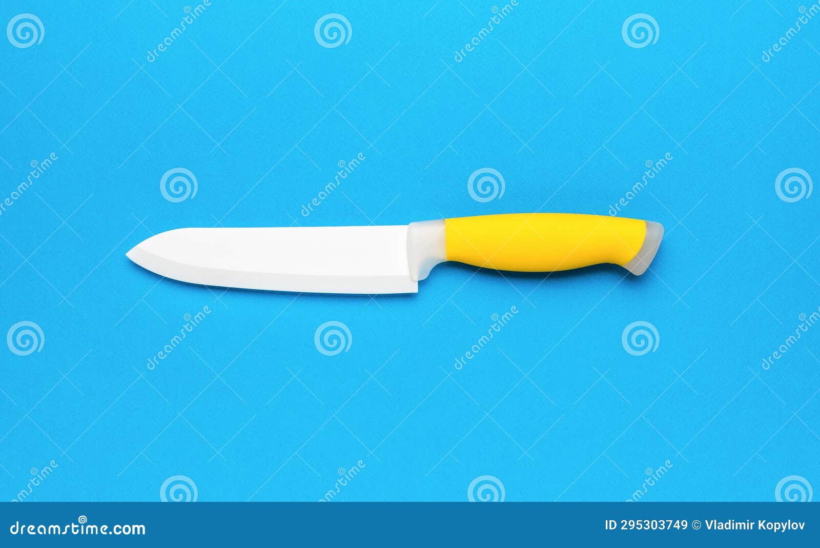 A Large Ceramic Kitchen Knife with a Yellow Handle on a Blue Background ...