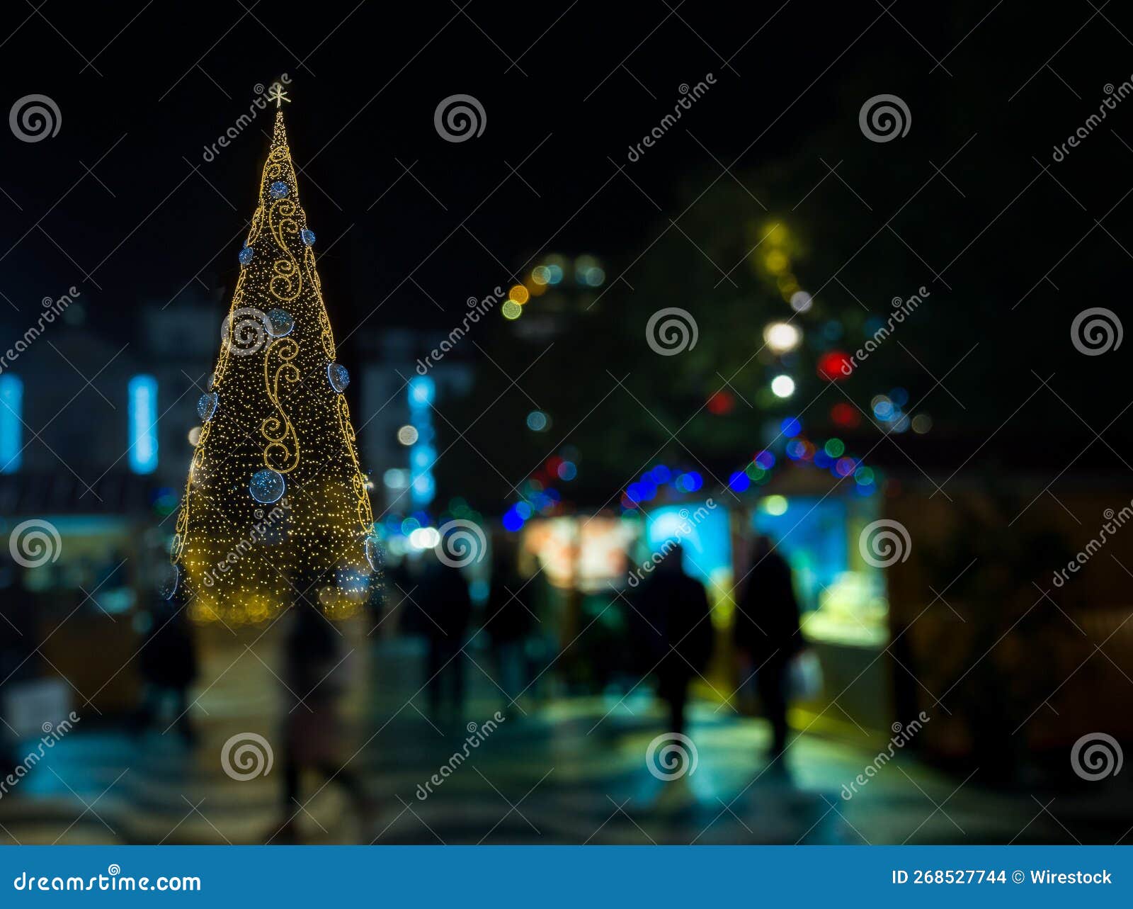 Large Christmas Tree in the City at Night with People Walking Around it ...