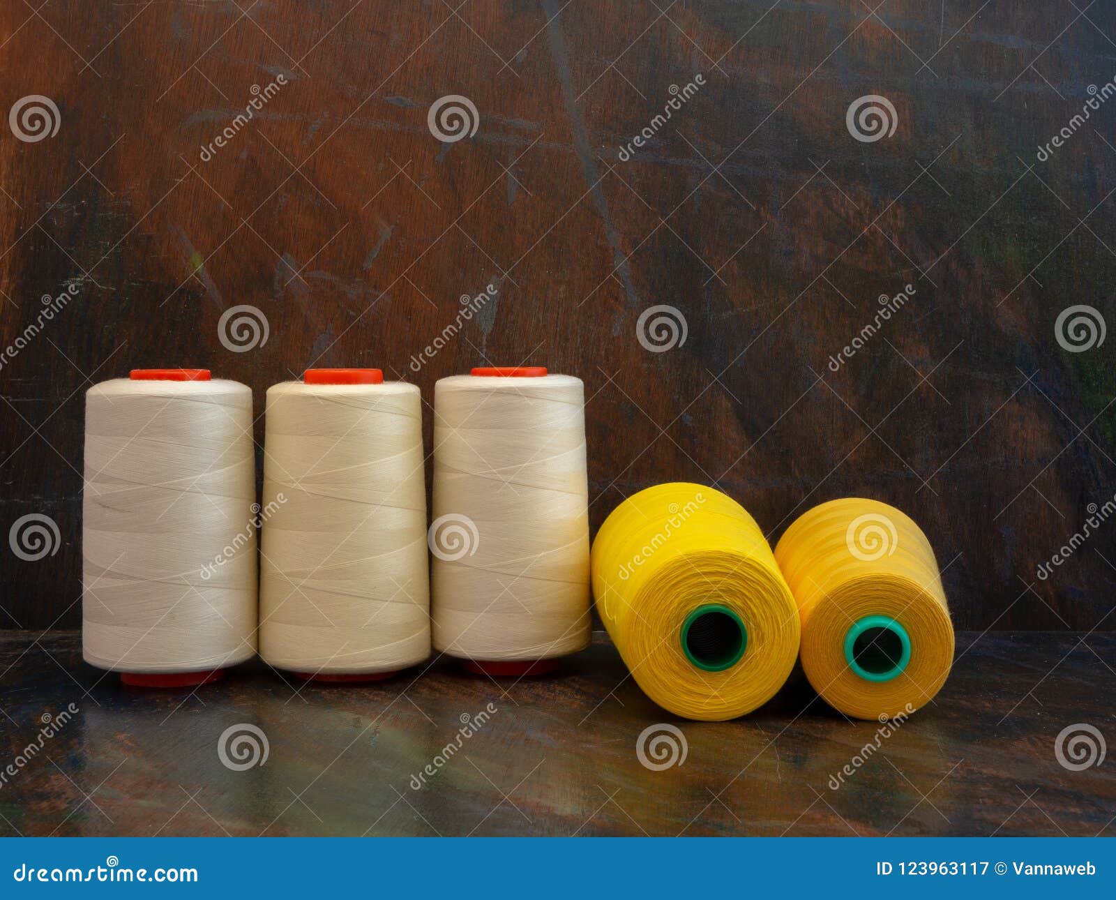 Industrial Cones of Yellow and White Sewing Threads Laying and Standing ...