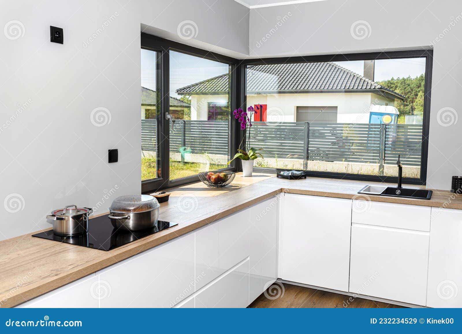 Large Corner Window in a Modern Kitchen with Built-in Cabinets Against ...
