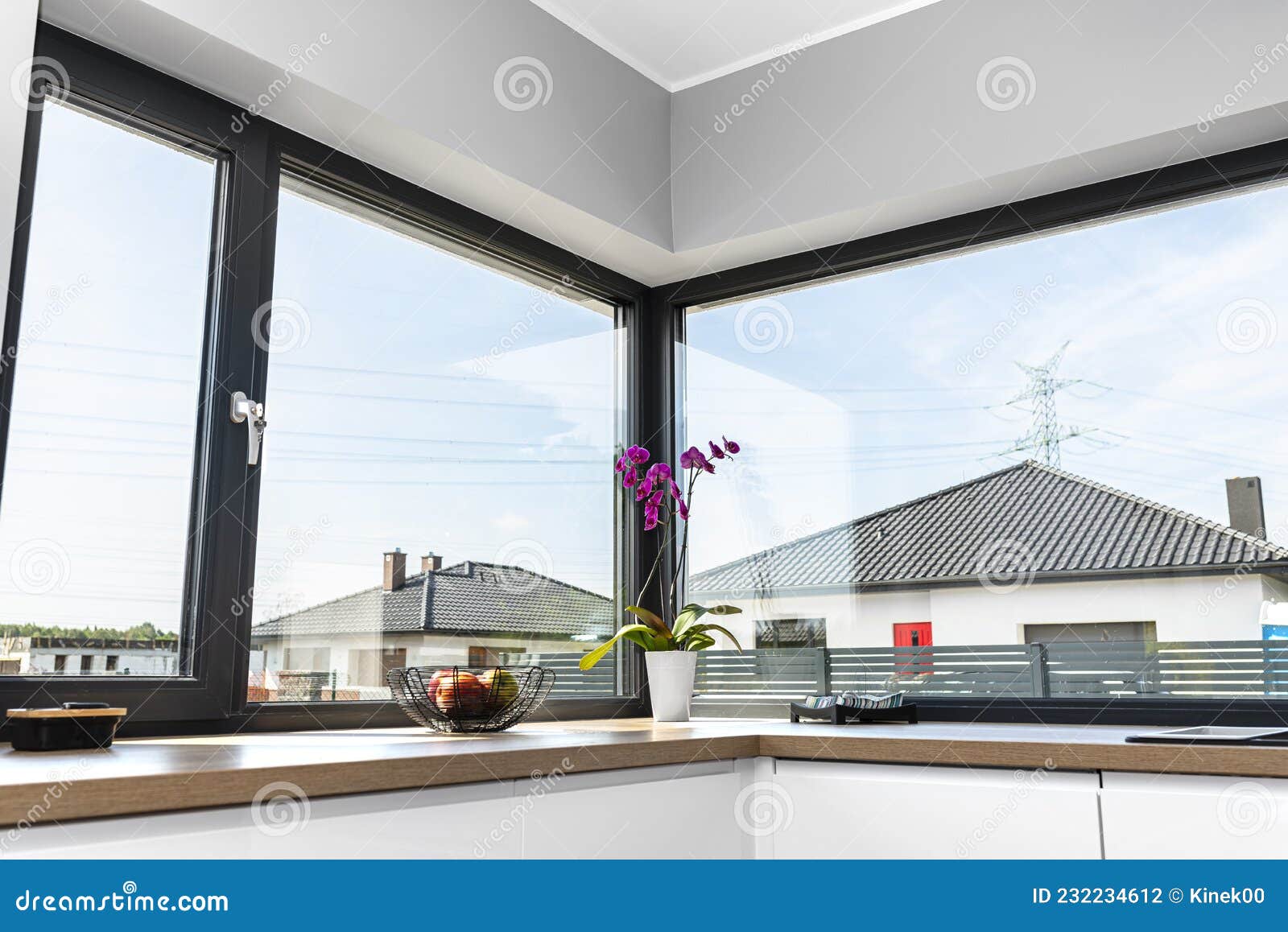 Large Corner Window in a Modern Kitchen with Built-in Cabinets Against ...