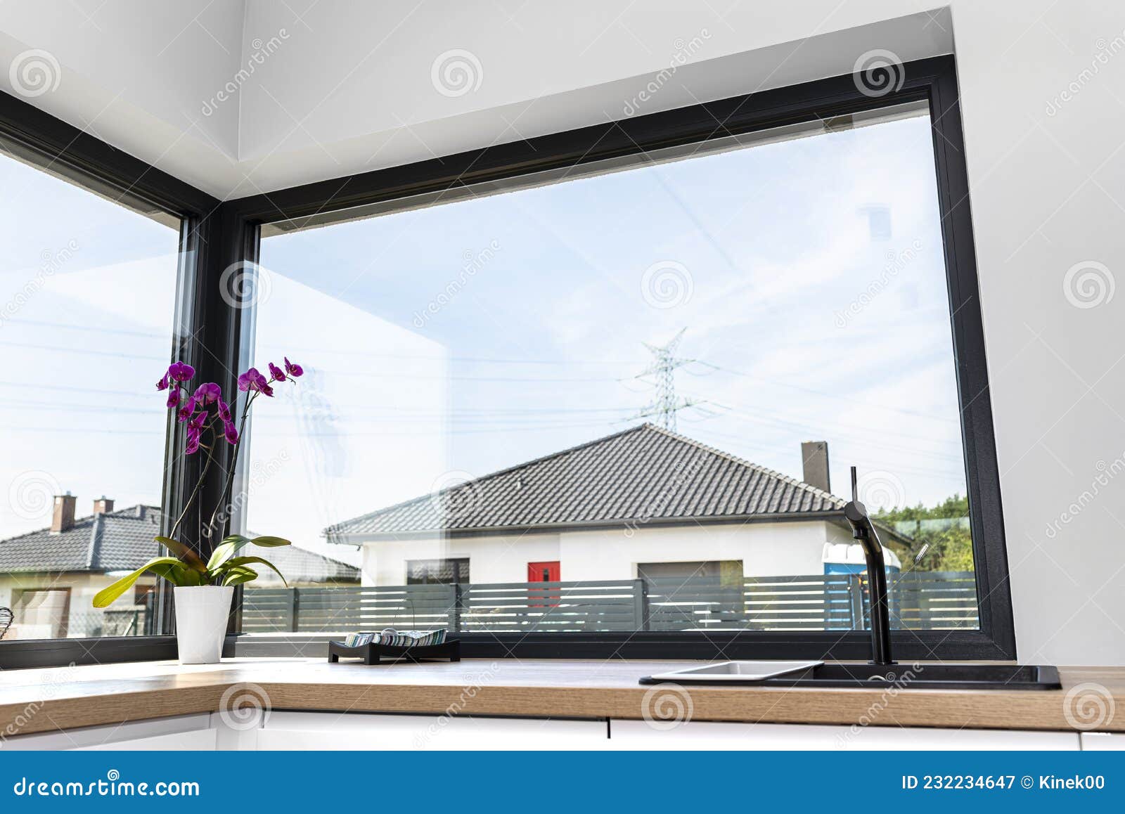 Large Corner Window in a Modern Kitchen with Built-in Cabinets Against ...