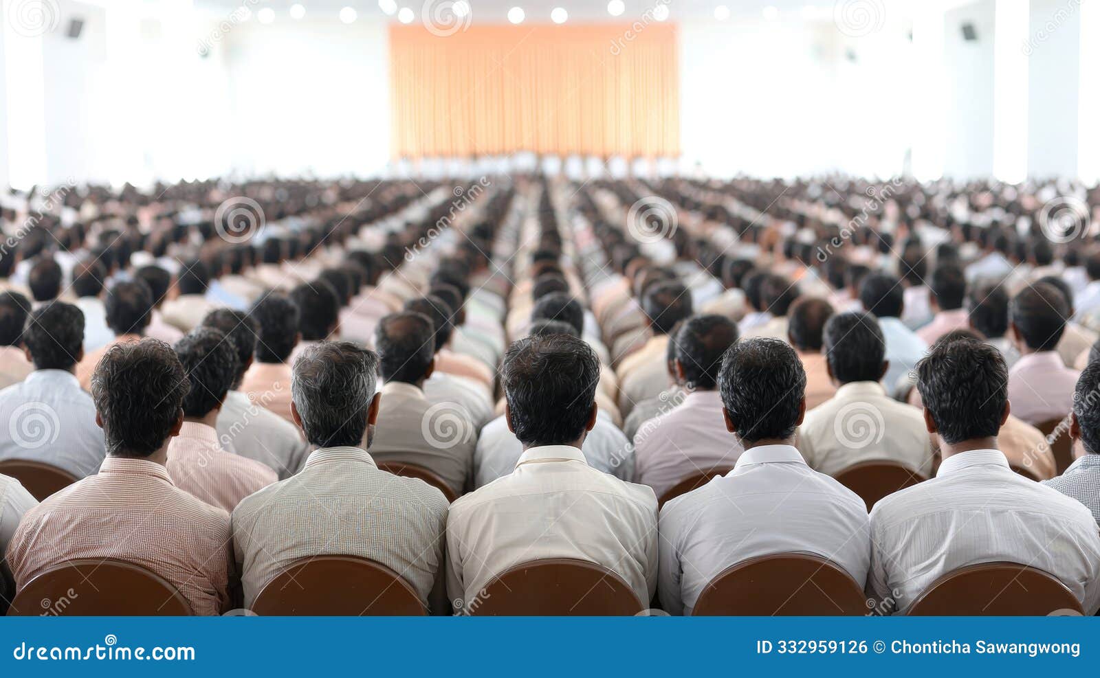 A Large Crowd of People Seated in Rows Facing a Stage, Waiting for a ...