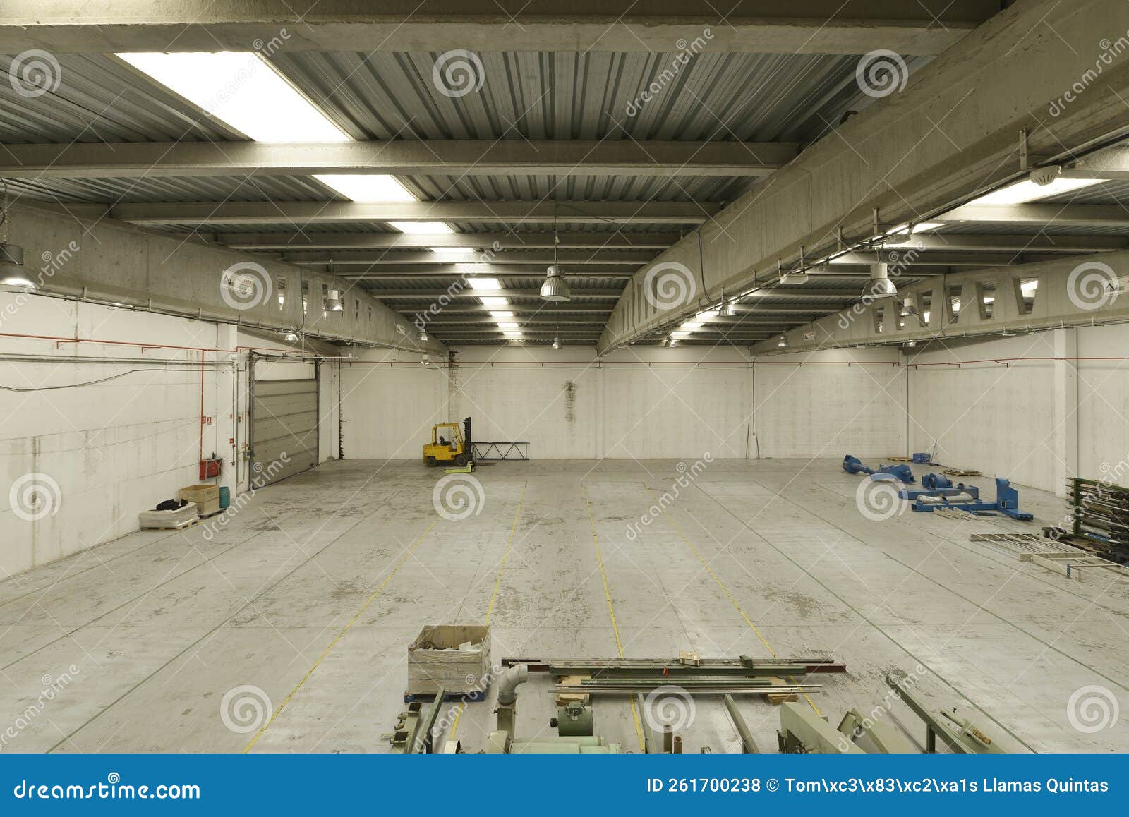 A Large Empty Industrial Warehouse with Concrete Floors and Skylights ...
