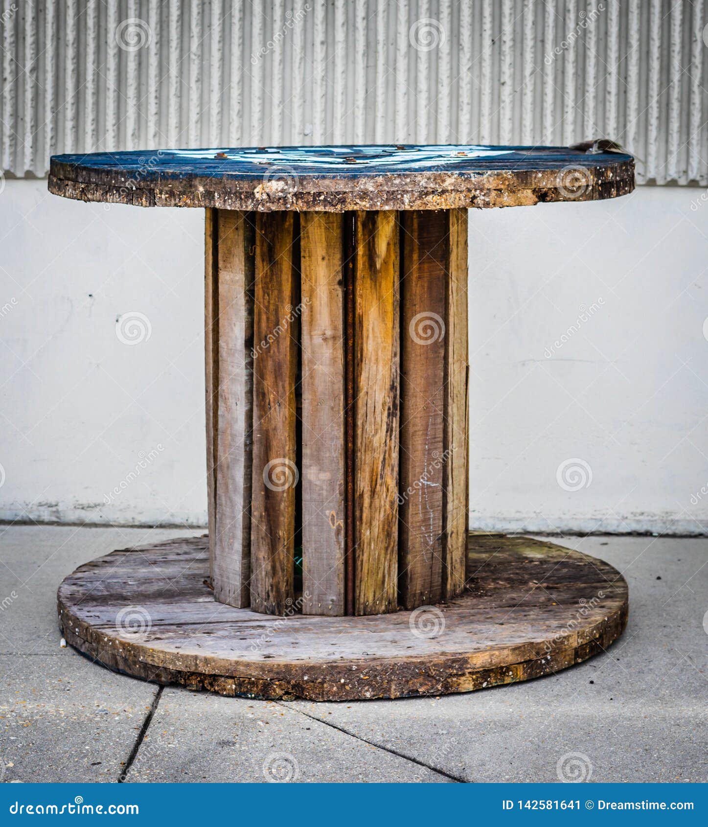 Large Empty Wooden Spool on Sidewalk, and a White Stripped Pattern Wall ...