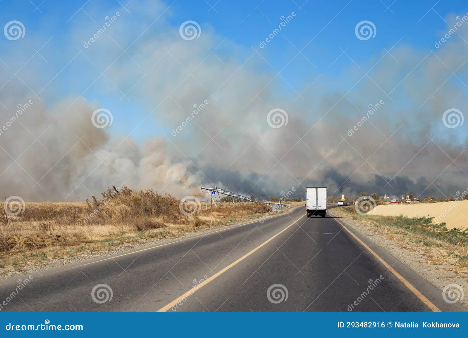 A Large Fire on the Side of the Road with Vehicles Moving. Smoke and ...
