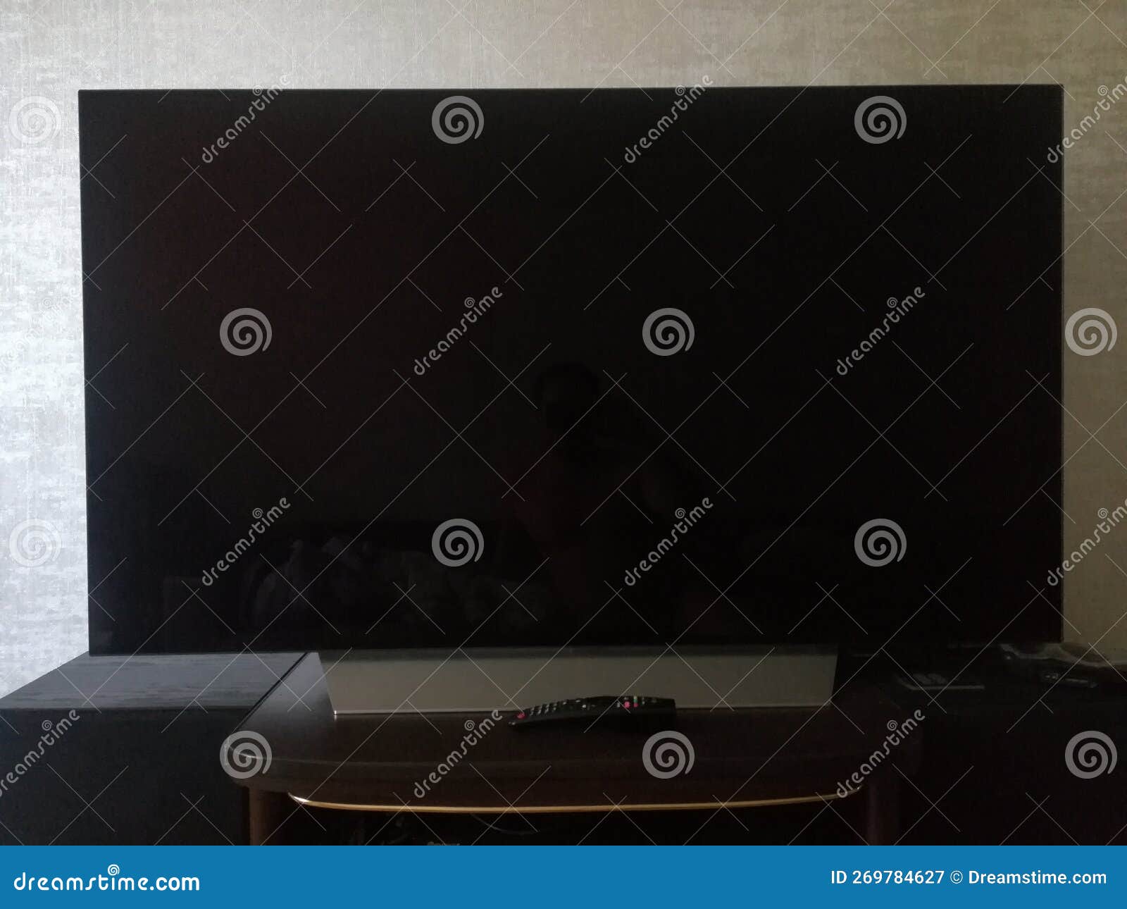 A Large Flat-screen TV Oled and a Remote Control for it in the Interior ...