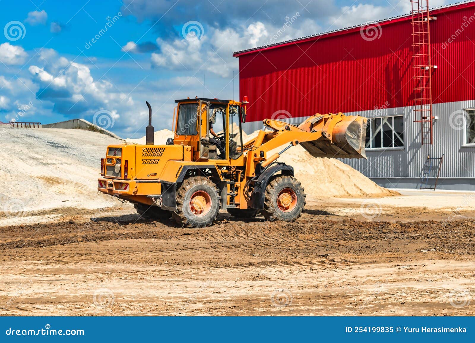 A Large Front Loader Pours Sand into a Pile at a Construction Site ...