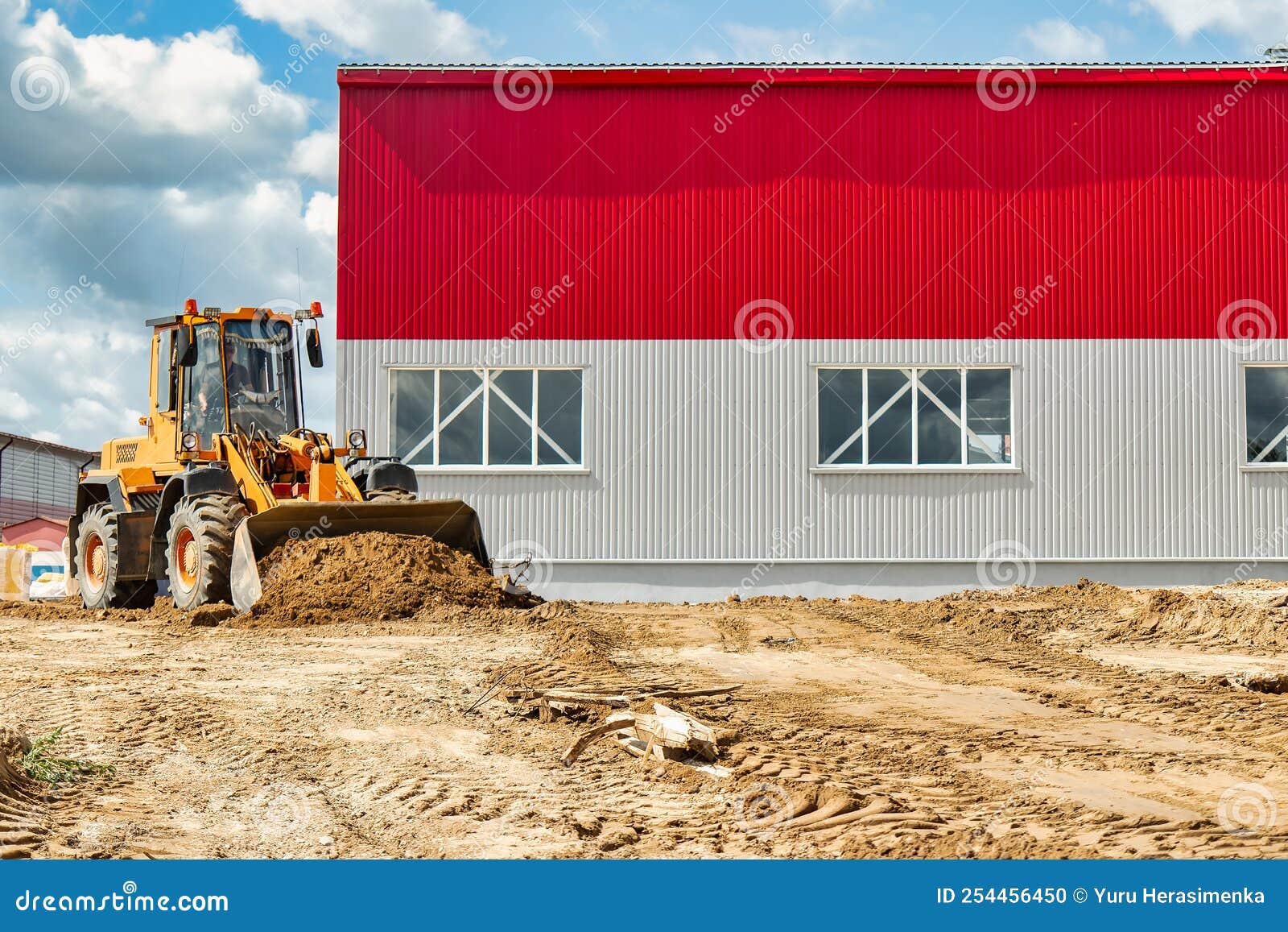A Large Front Loader Pours Sand into a Pile at a Construction Site ...