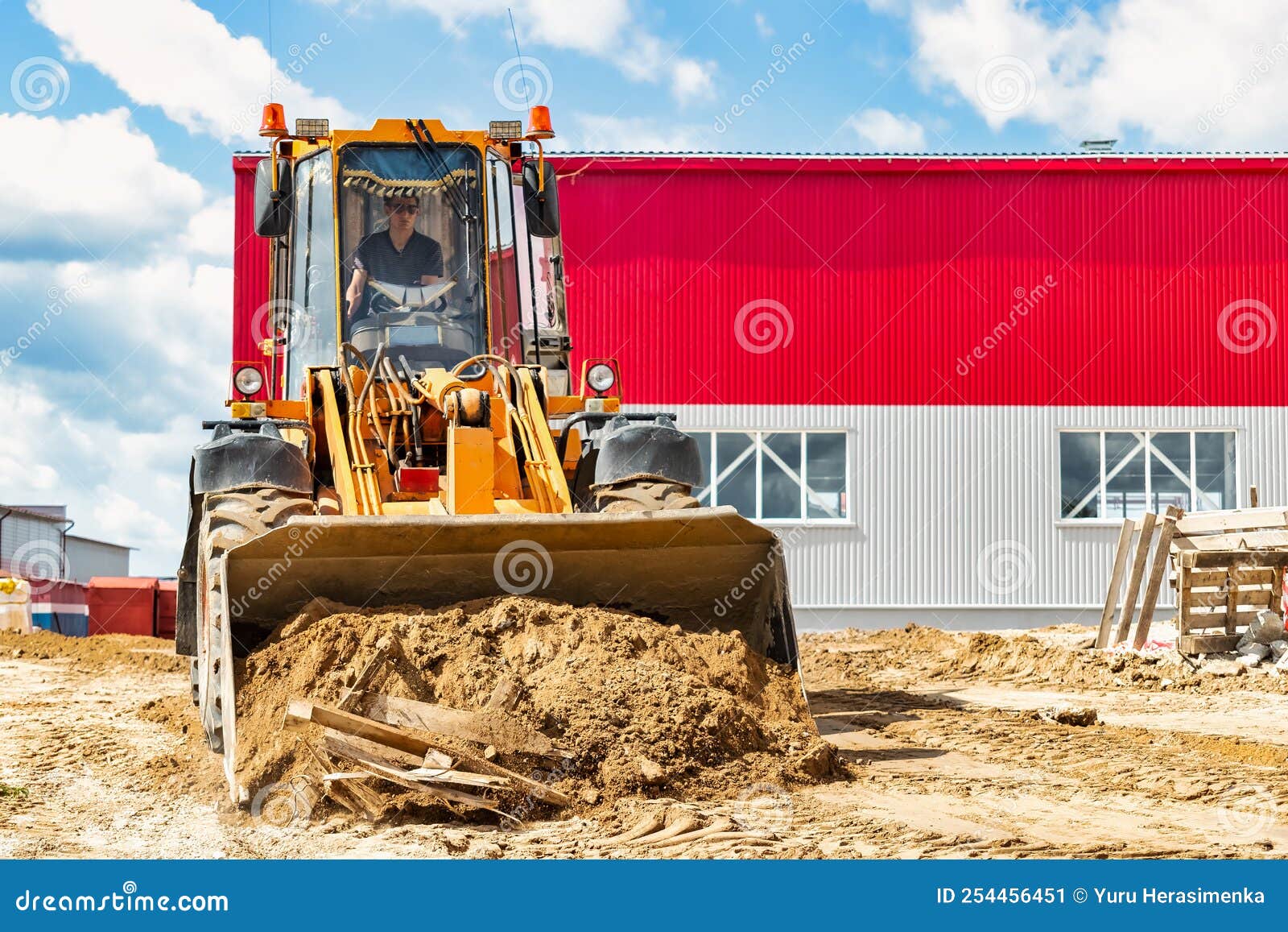 A Large Front Loader Pours Sand into a Pile at a Construction Site ...