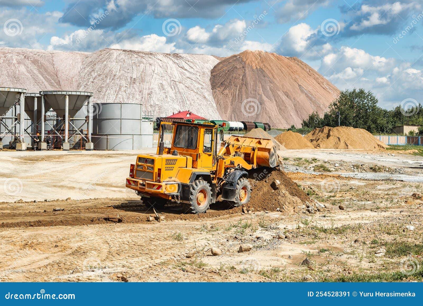 A Large Front Loader Pours Sand into a Pile at a Construction Site ...