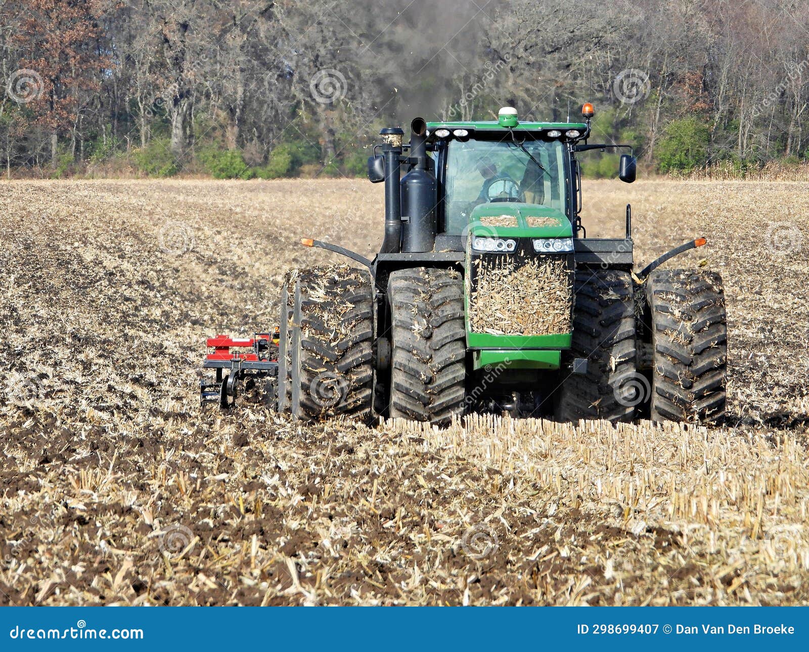 Large Green Tractor with 8 Wheels Pulling a Chisel Plough Over a Picked ...